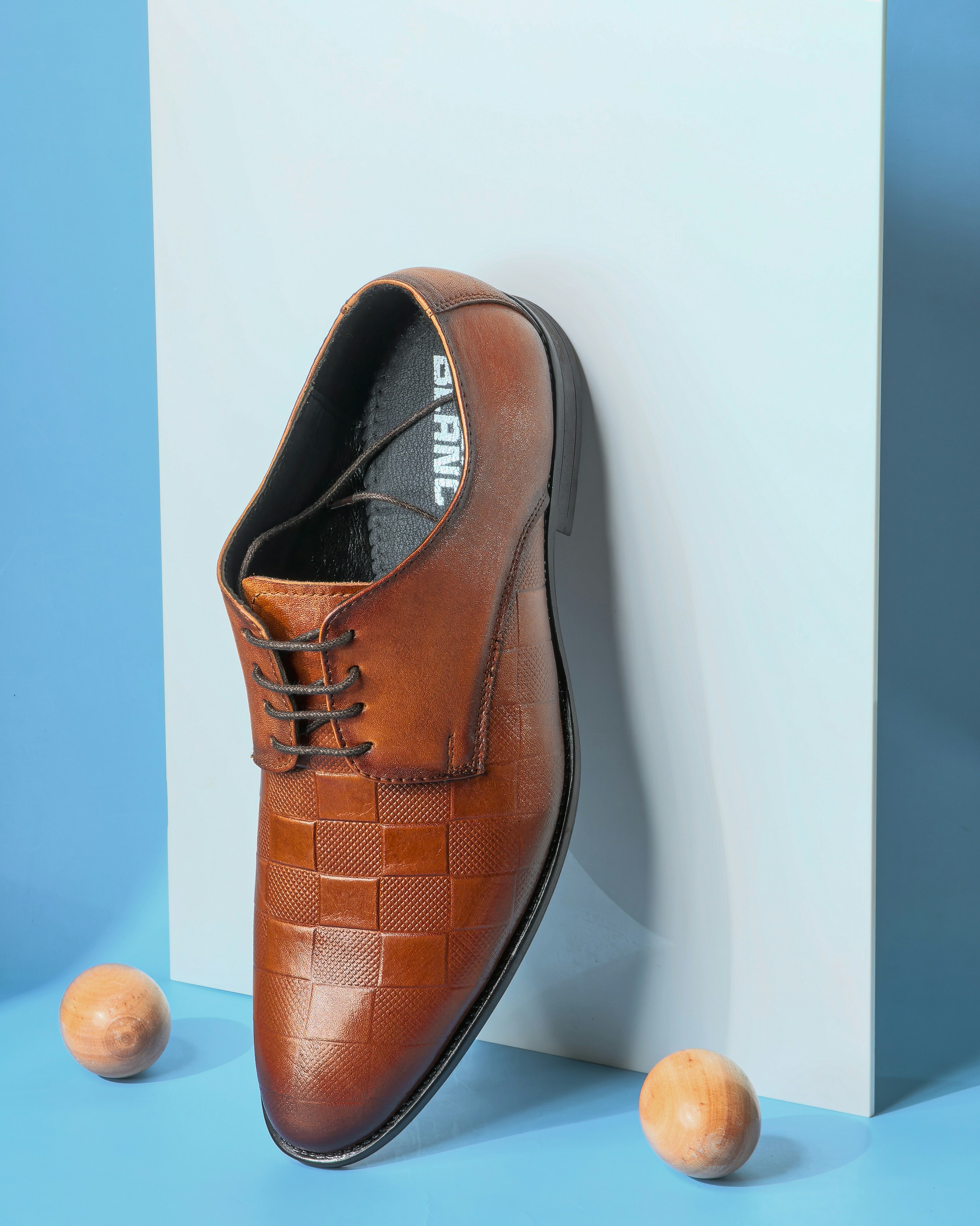Brown Checkerboard Oxford on a Powder-Blue Stage with Wooden Orbs