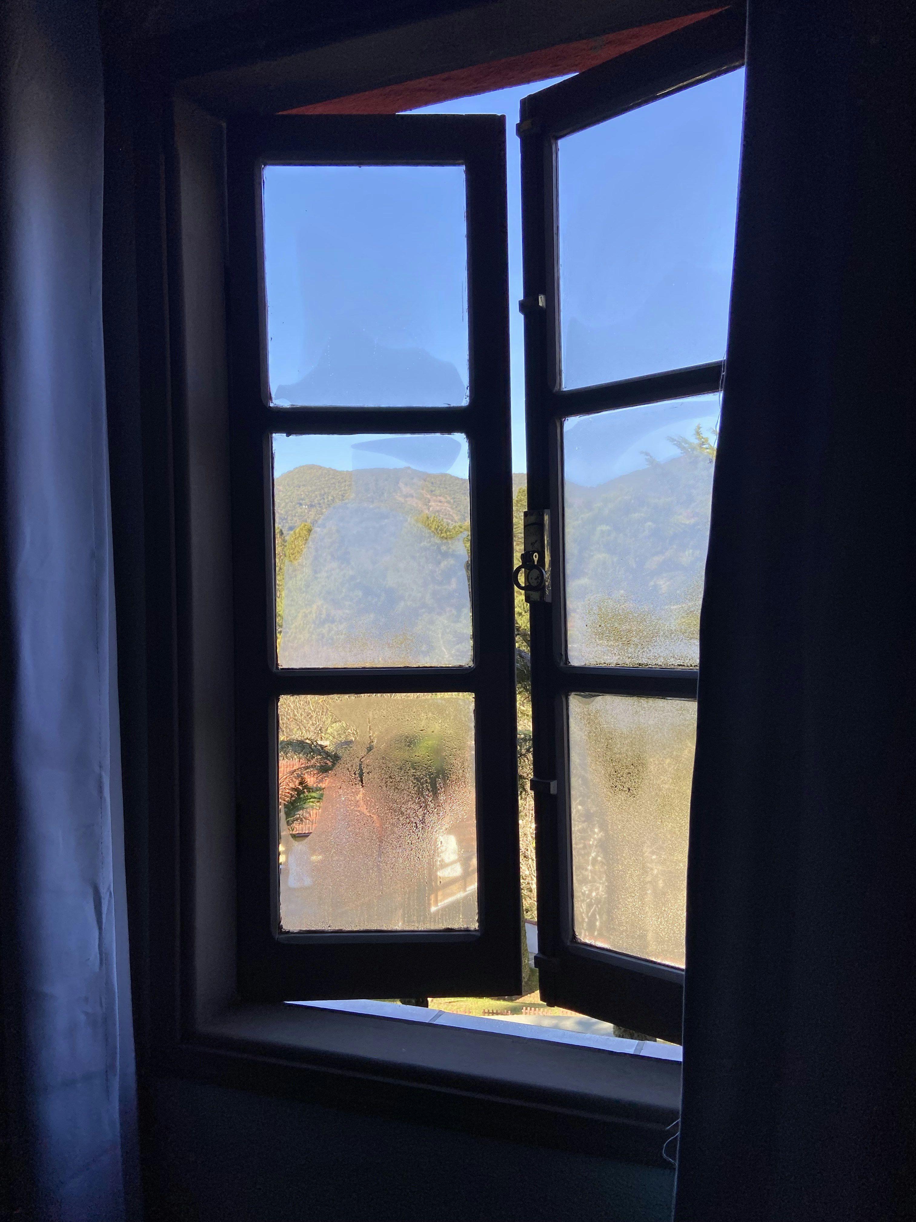 Curtain-Frame Vista: Mountains Through an Open Window