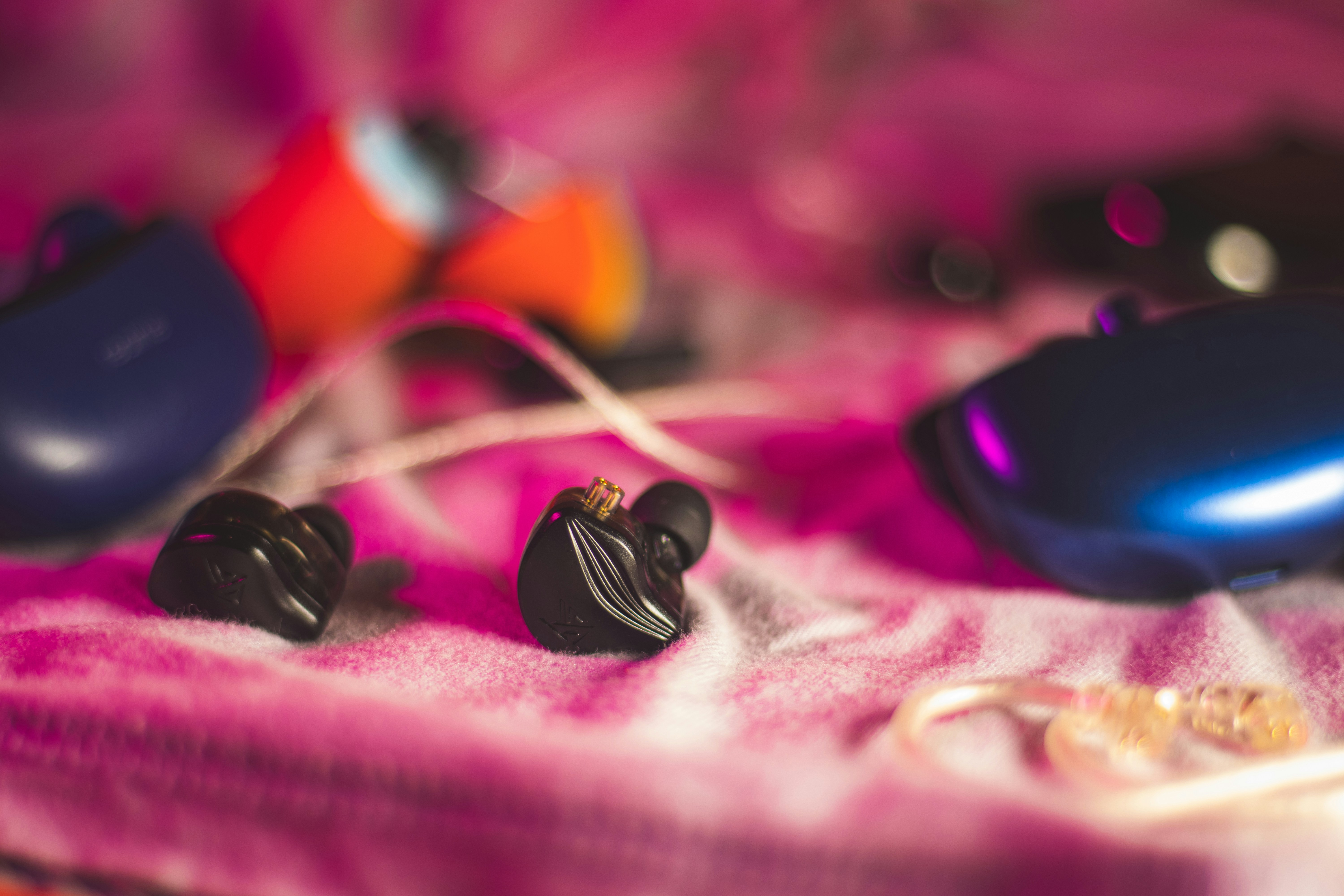 A pair of ear buds sitting on top of a pink blanket photo – Free Danara ...