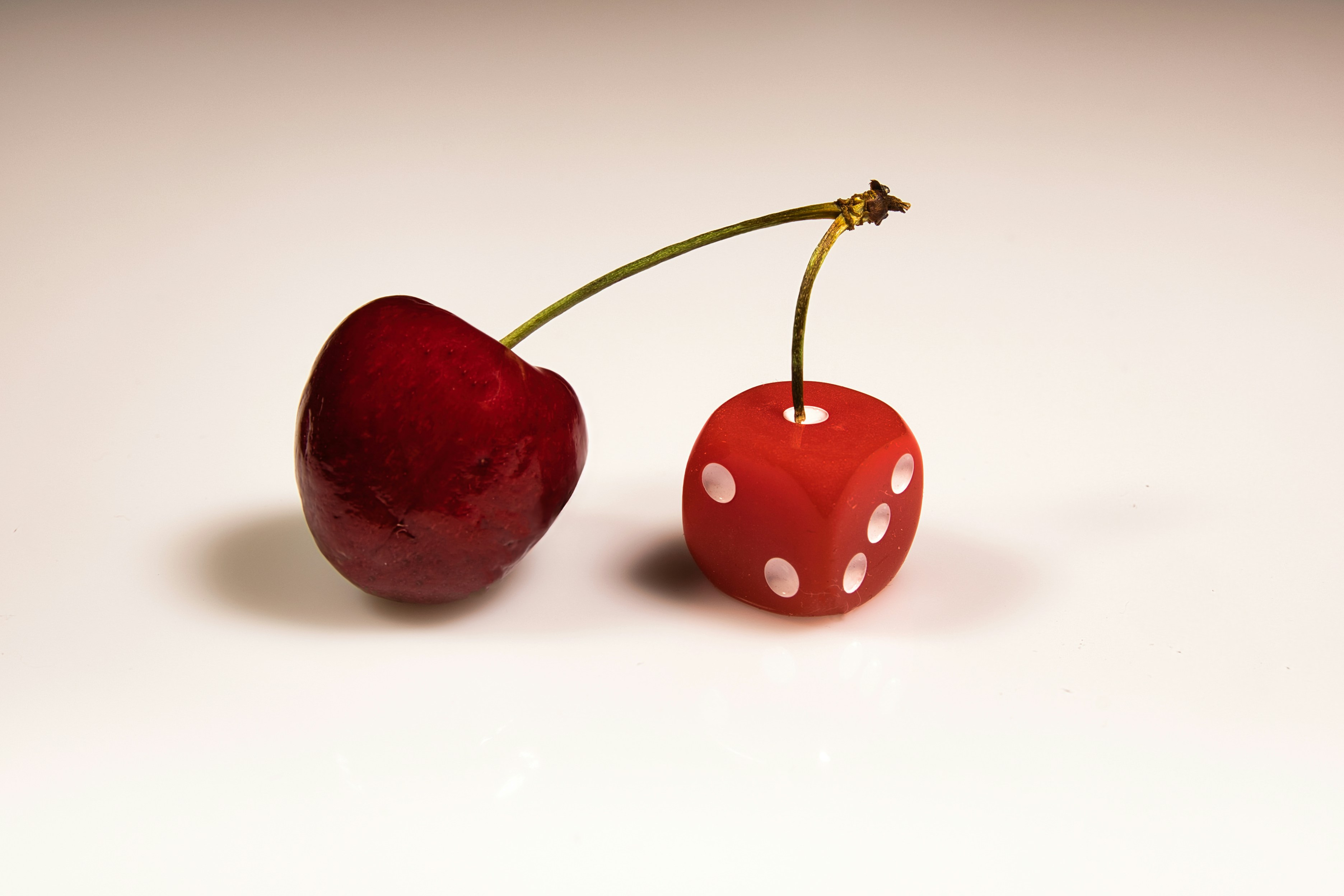 A couple of cherries sitting on top of a white table photo – Free Food ...