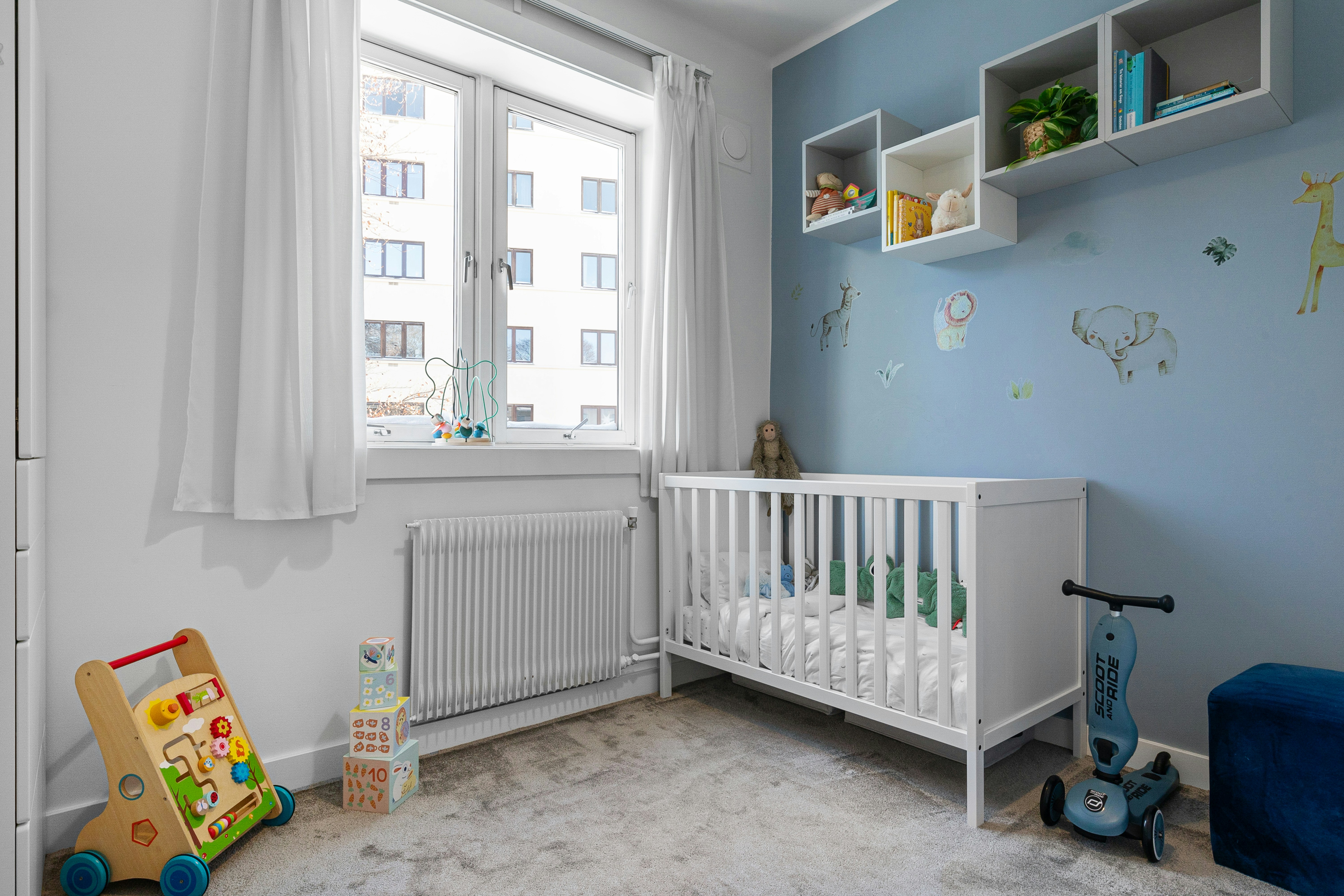 Bright, airy nursery featuring a crib, playful toys, and whimsical wall decor. Soft natural light enhances the serene atmosphere.