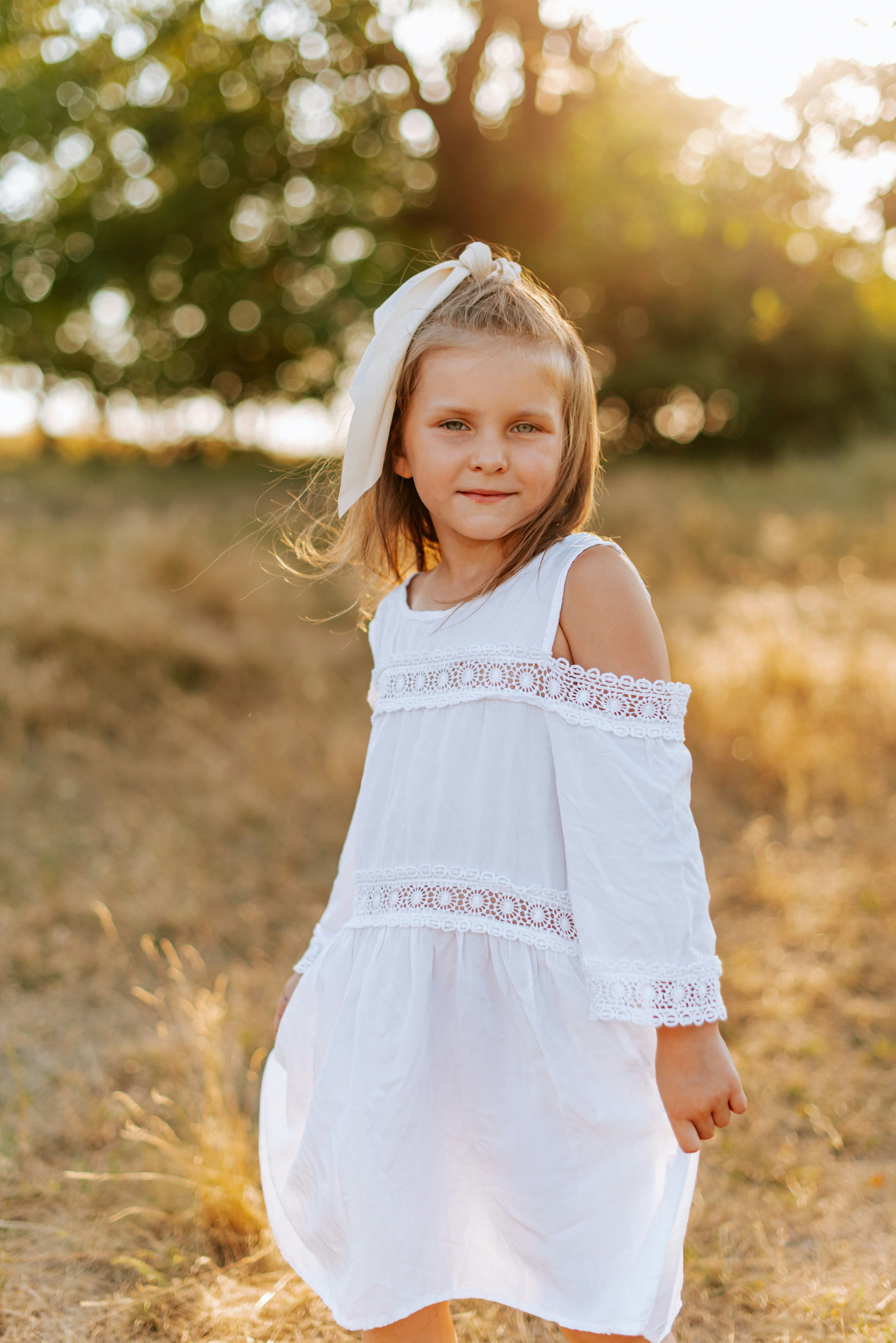 A little girl in a white dress standing in a field photo – Free Face ...