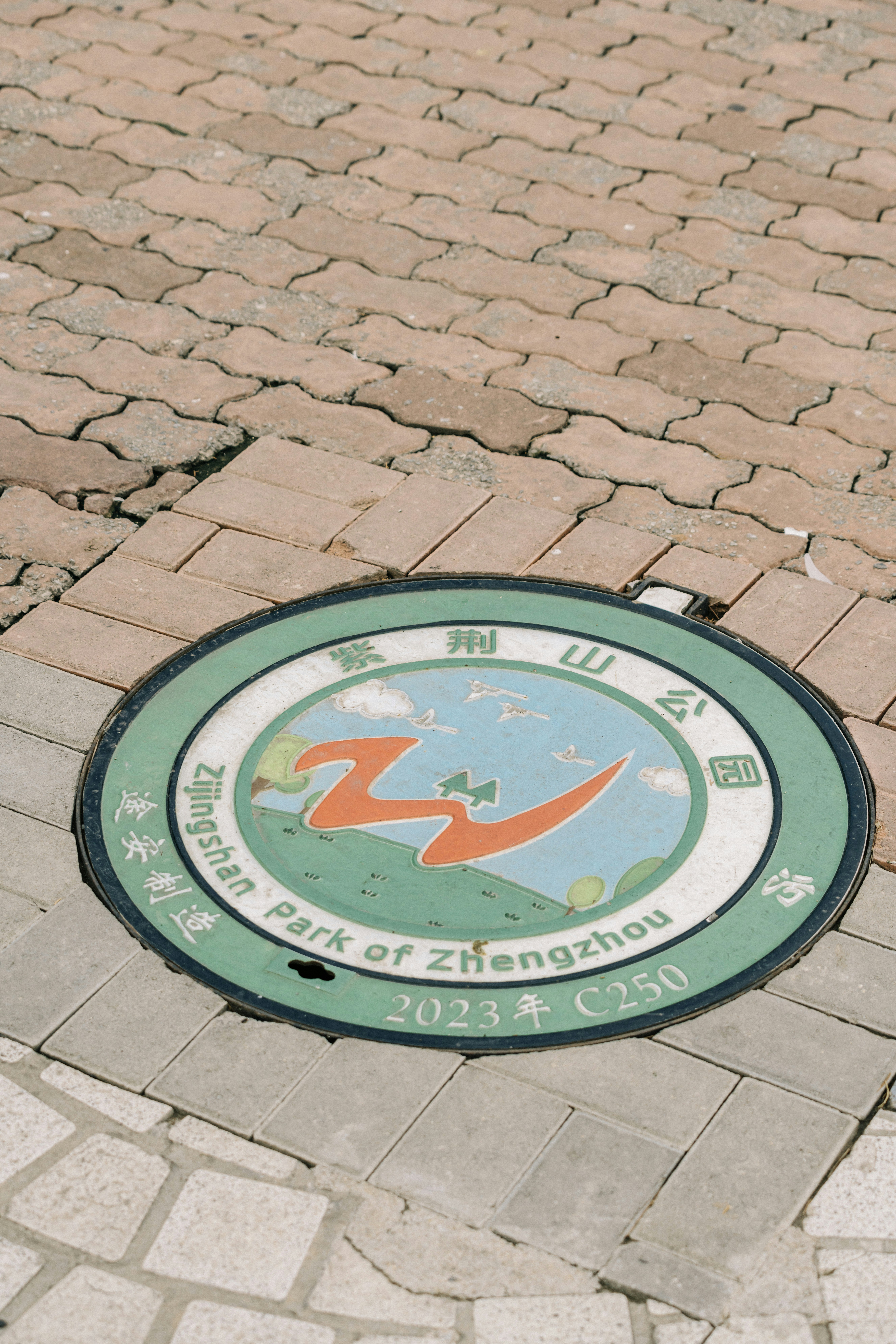 A manhole cover sitting on a brick sidewalk photo – Free Path Image on ...