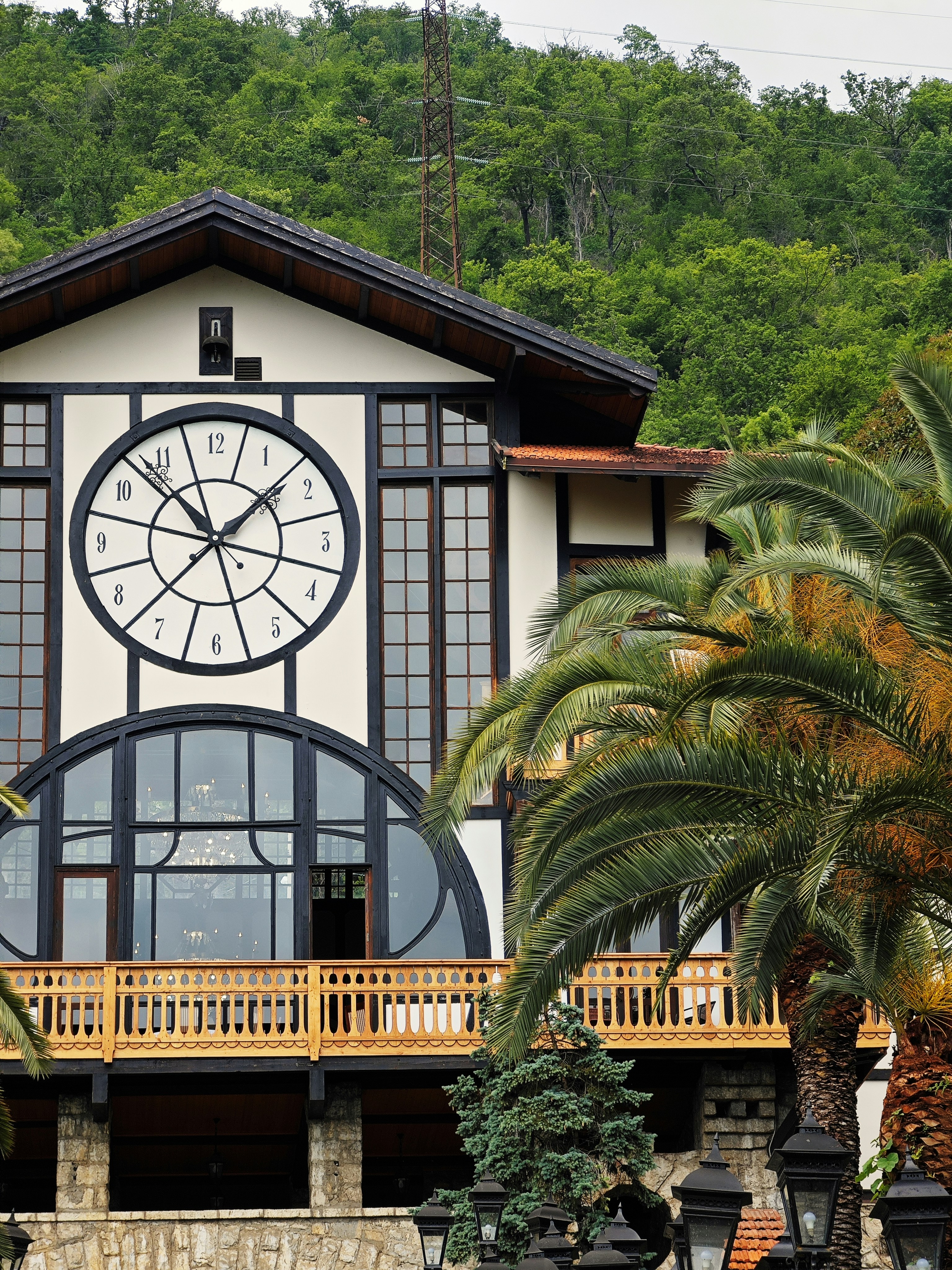 Timekeeper's Facade: A Clock on Timber-Walled Architecture Framed by Palms
