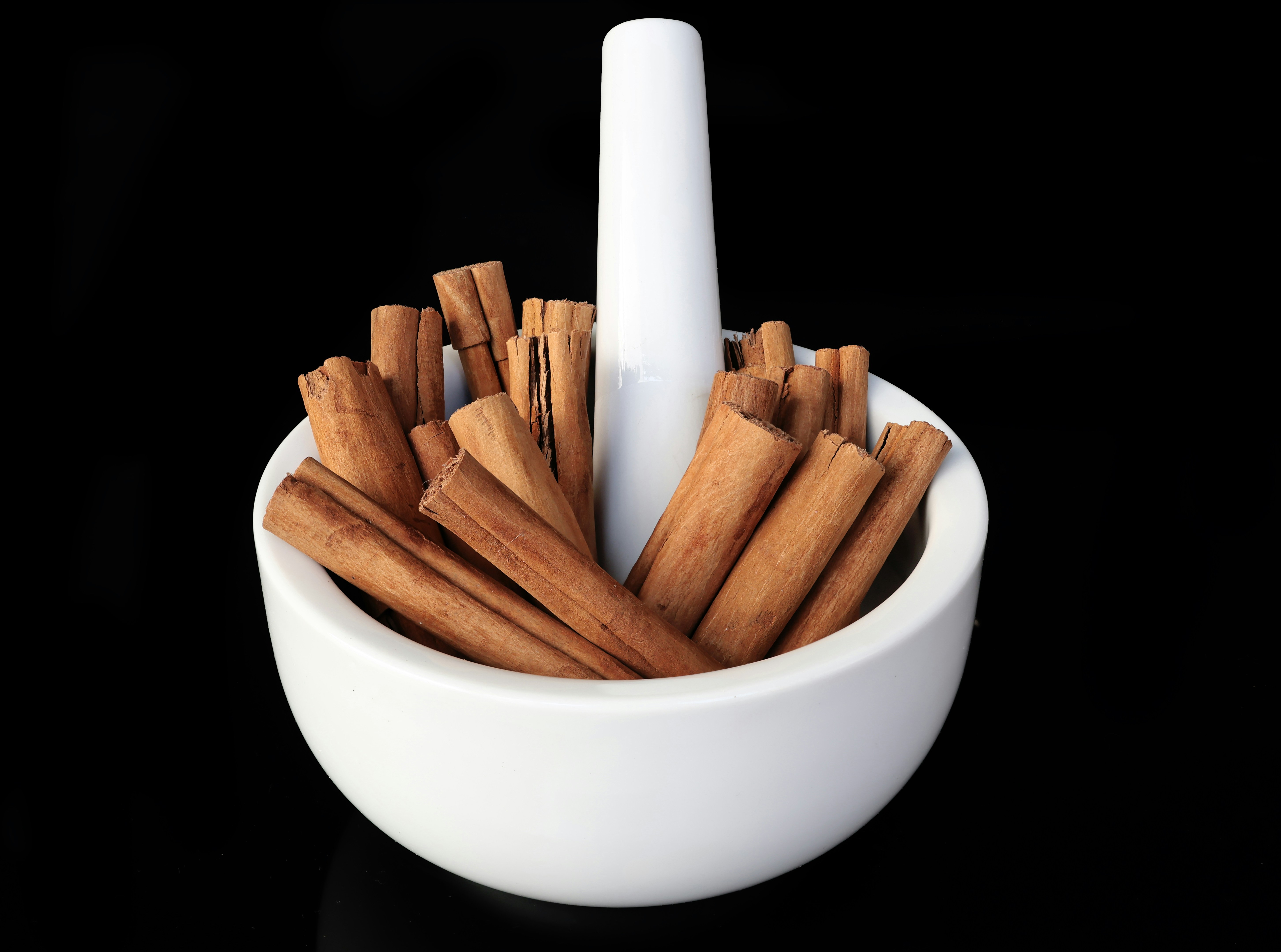 White Mortar, Cinnamon Sticks: A Minimalist Still-Life in Black
