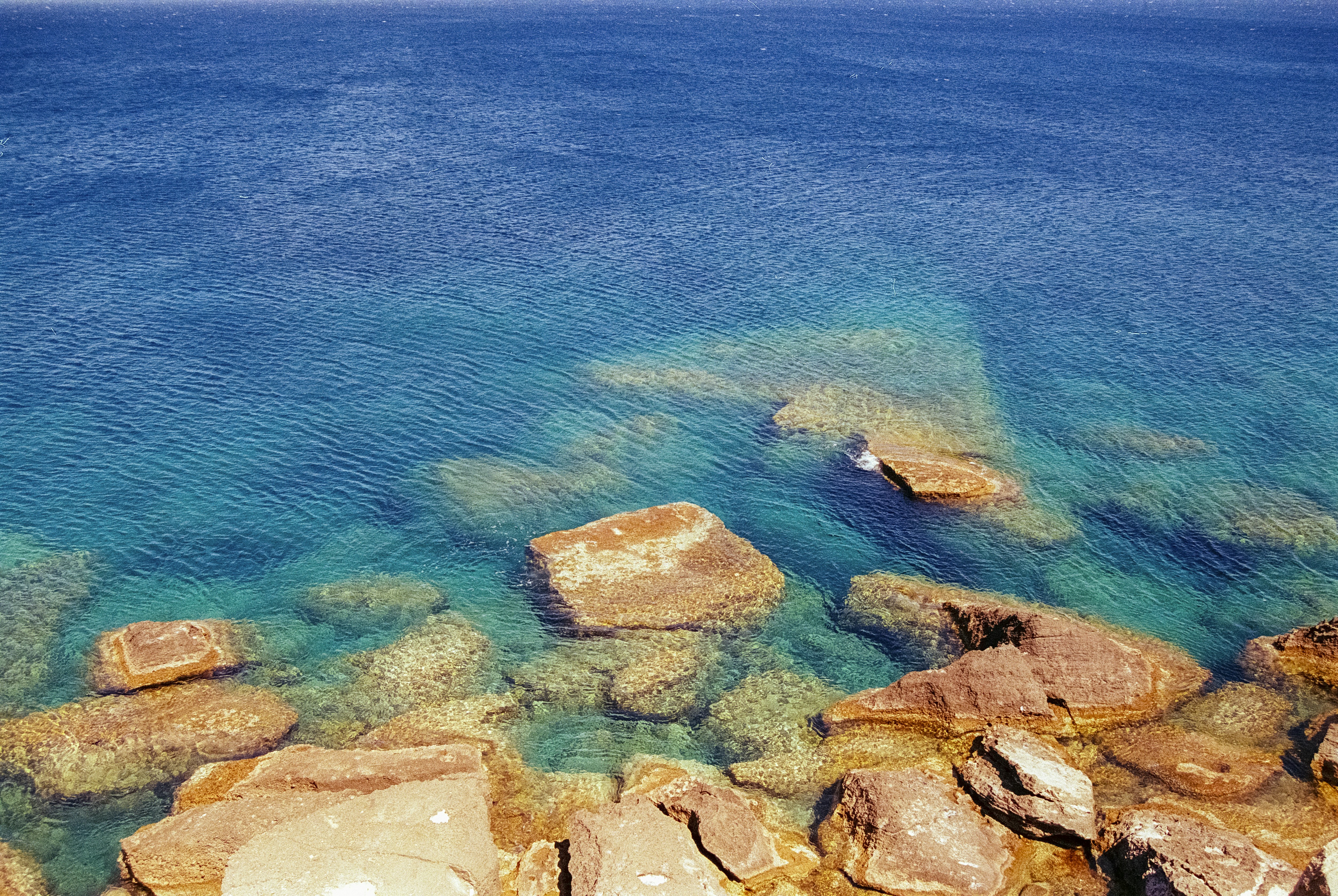 A body of water surrounded by rocks and water photo – Free Greece Image ...
