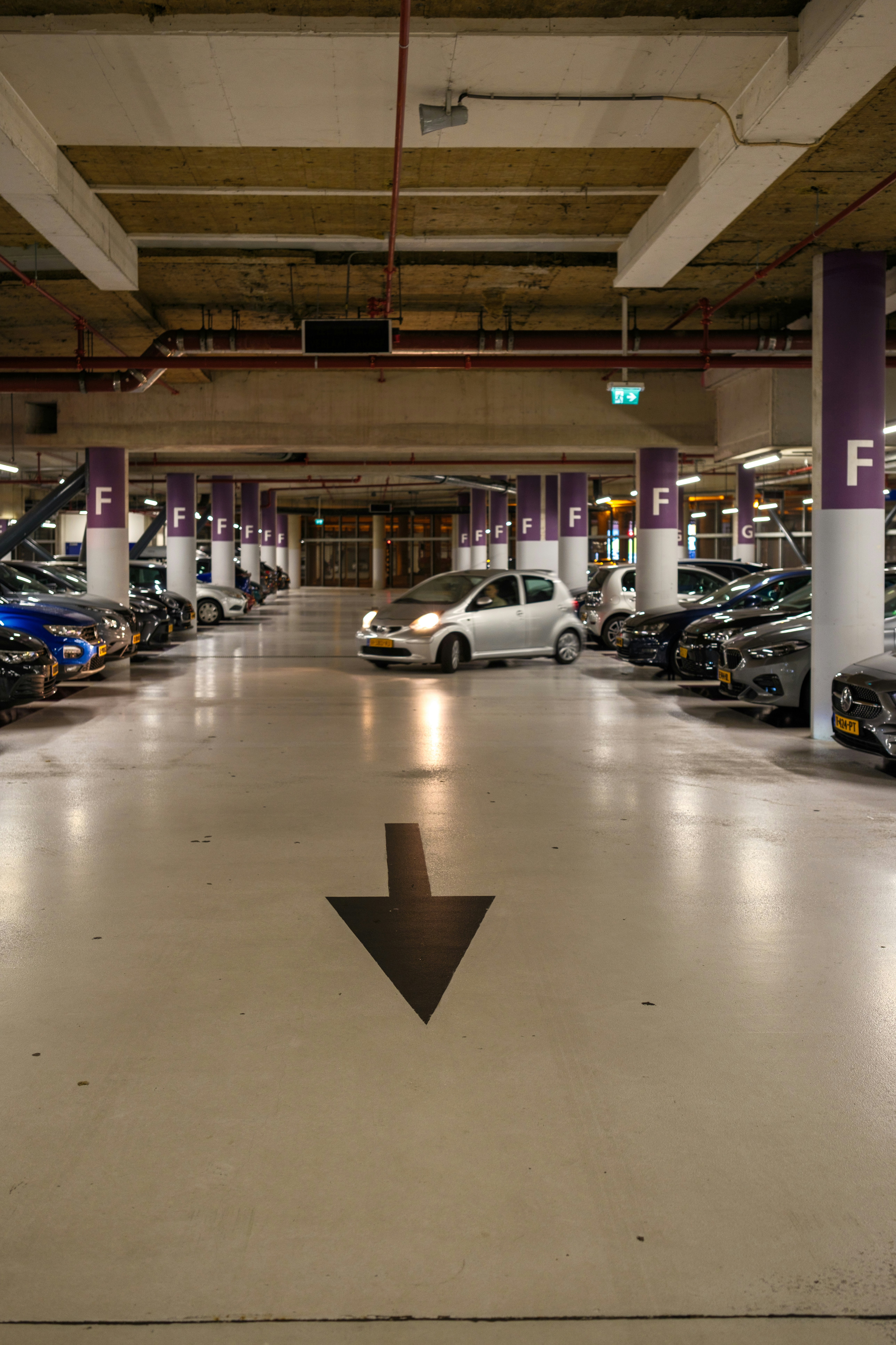 A parking garage filled with lots of parked cars photo – Free Parking ...
