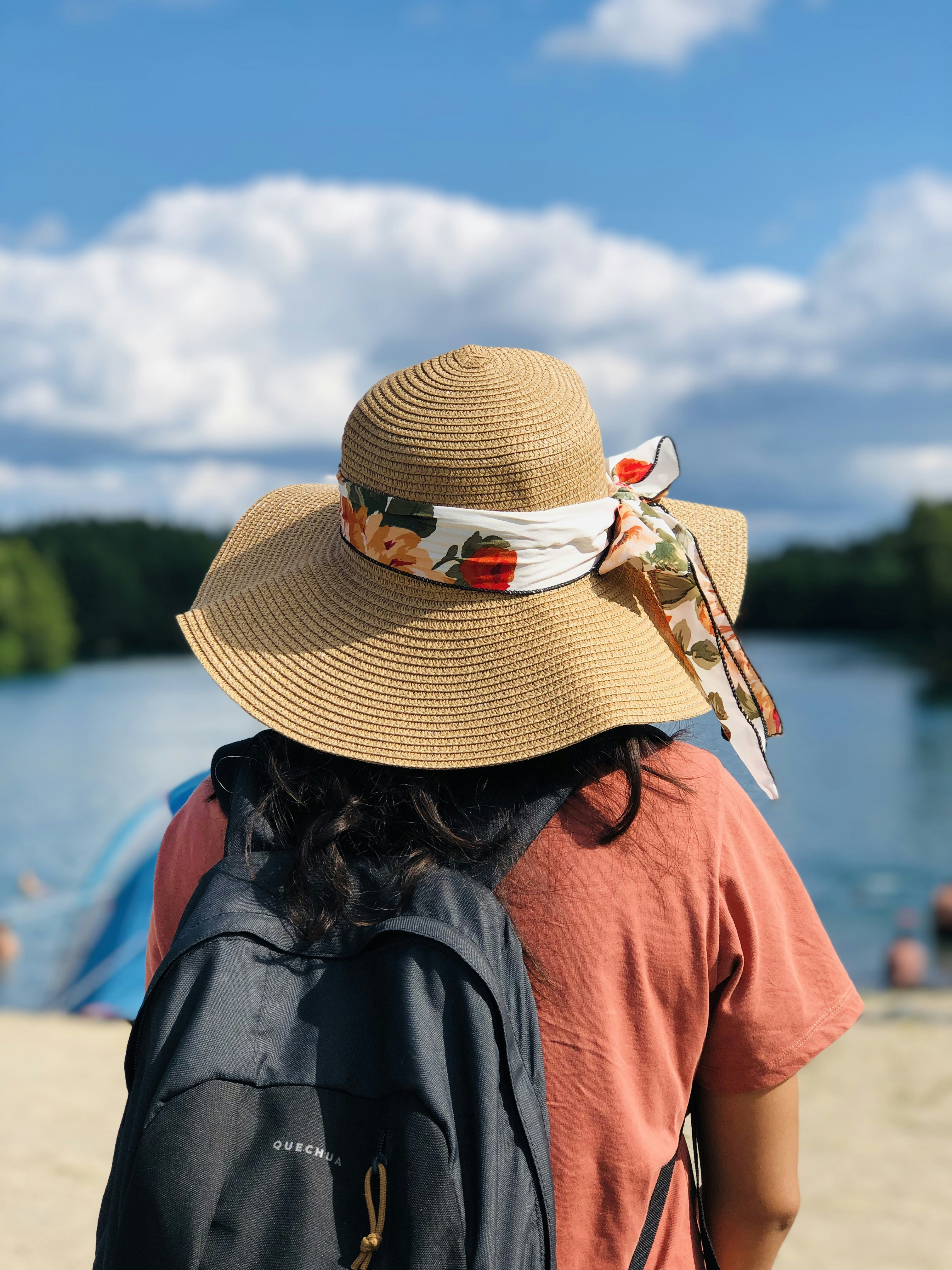 Riverside Silhouette: Straw Hat and Backpack in Sunlit Calm