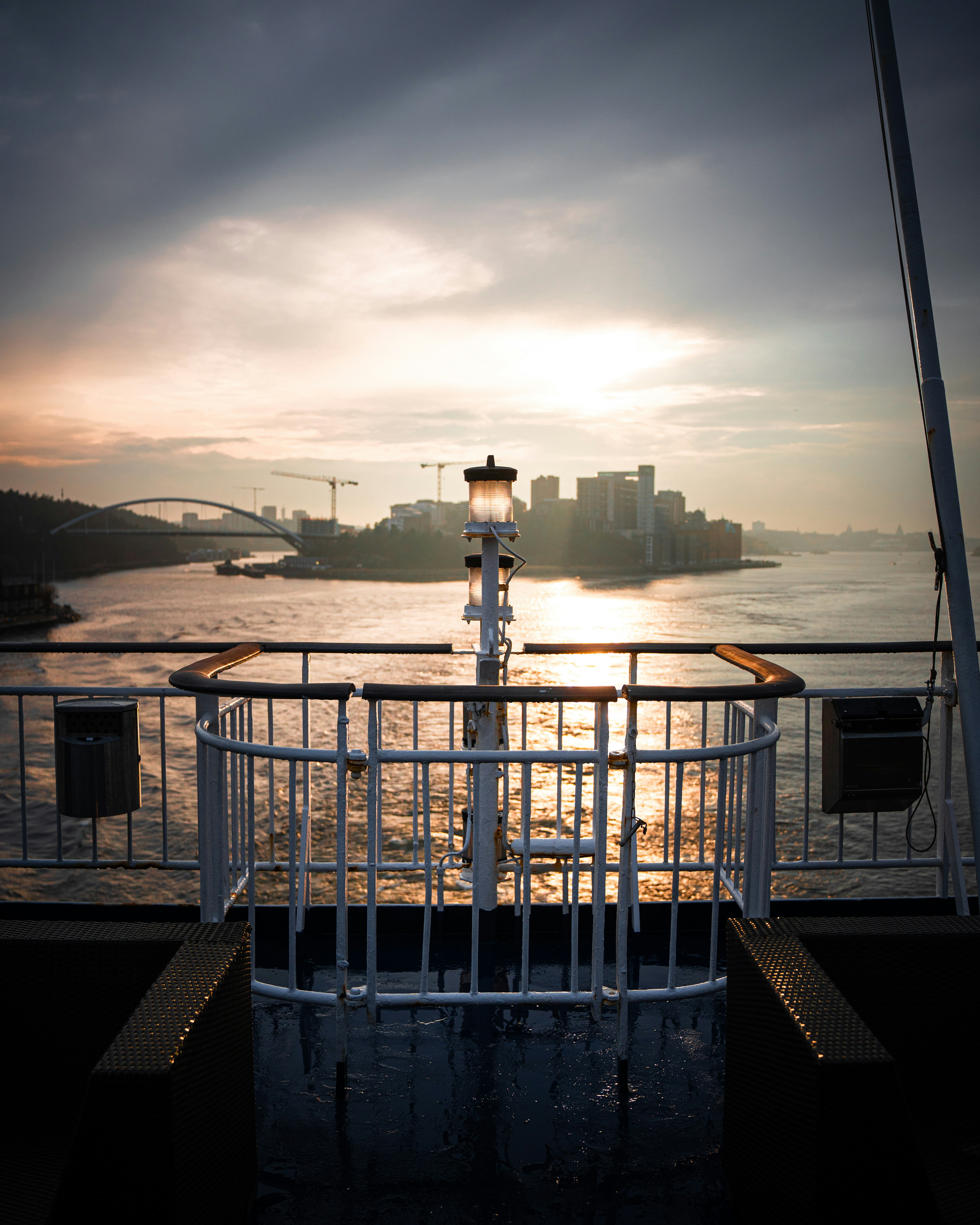 Bow Lantern Silhouette: Sunset Reflections over a Riverside Skyline