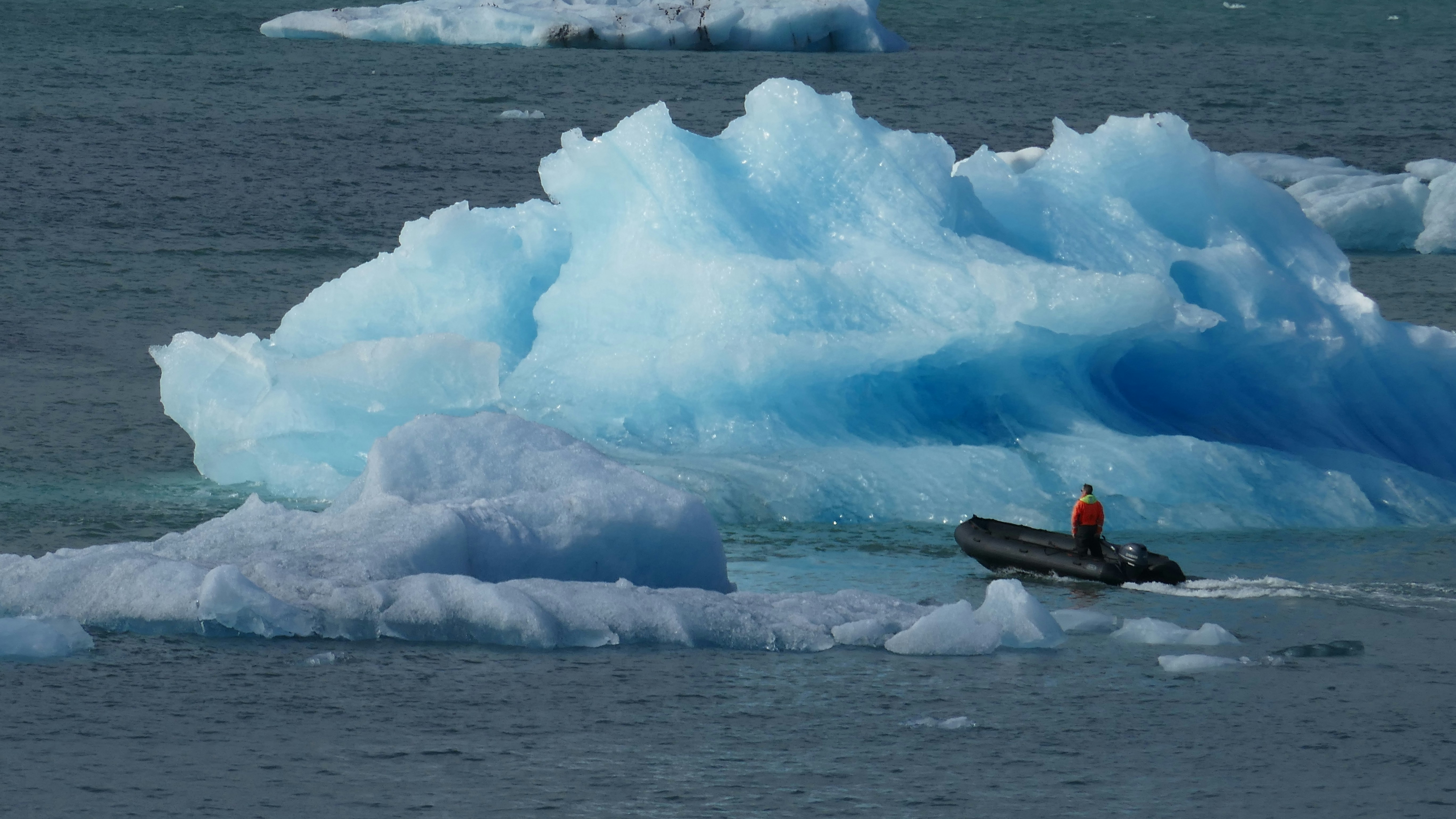 Orange Jacket, Blue Giants: A Tiny Boat at the Edge of Arctic Ice