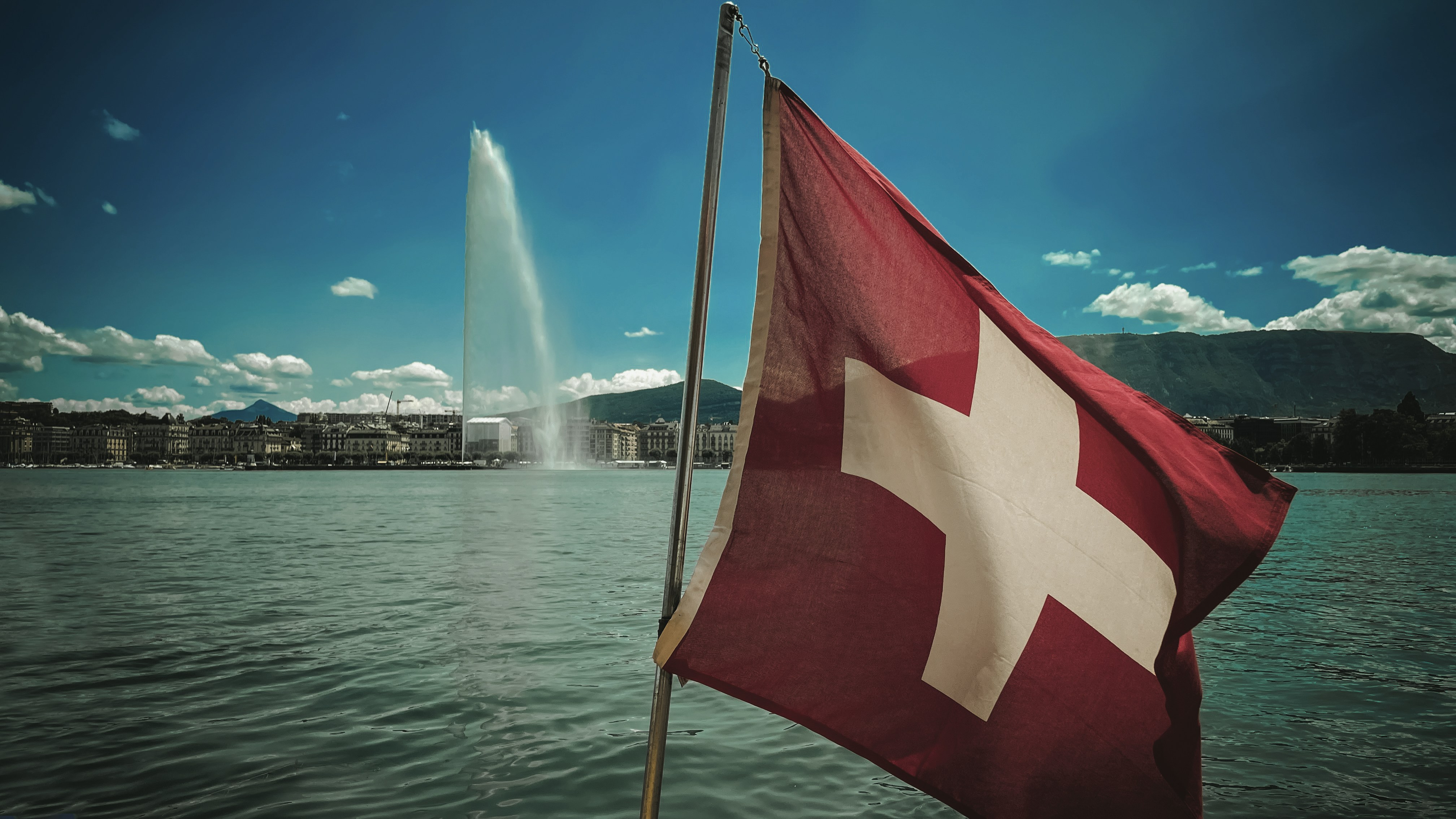 A swiss flag flying in front of a fountain photo – Free Flag Image on ...