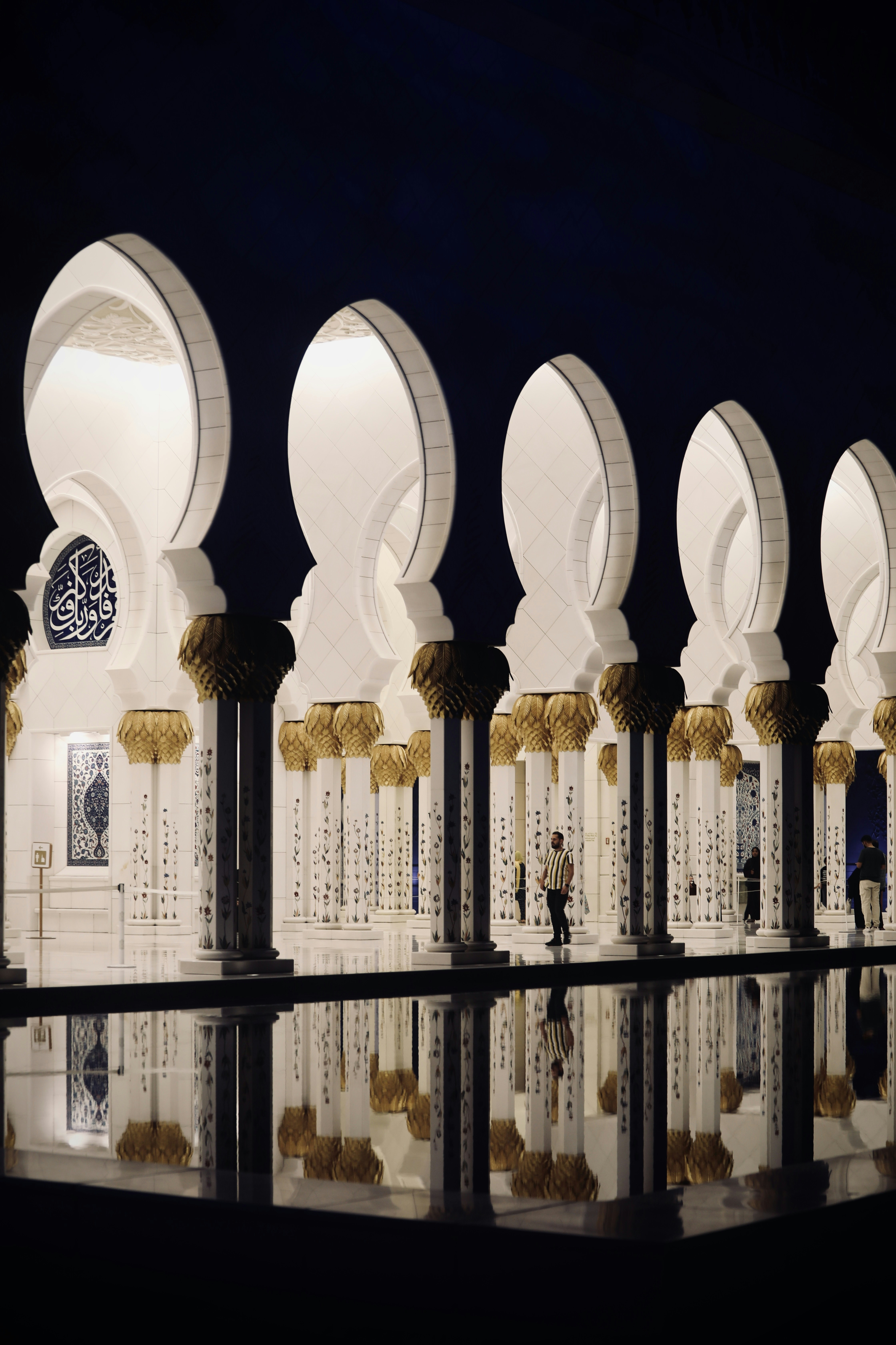 A row of white arches with a reflection in the water photo – Free Abu ...