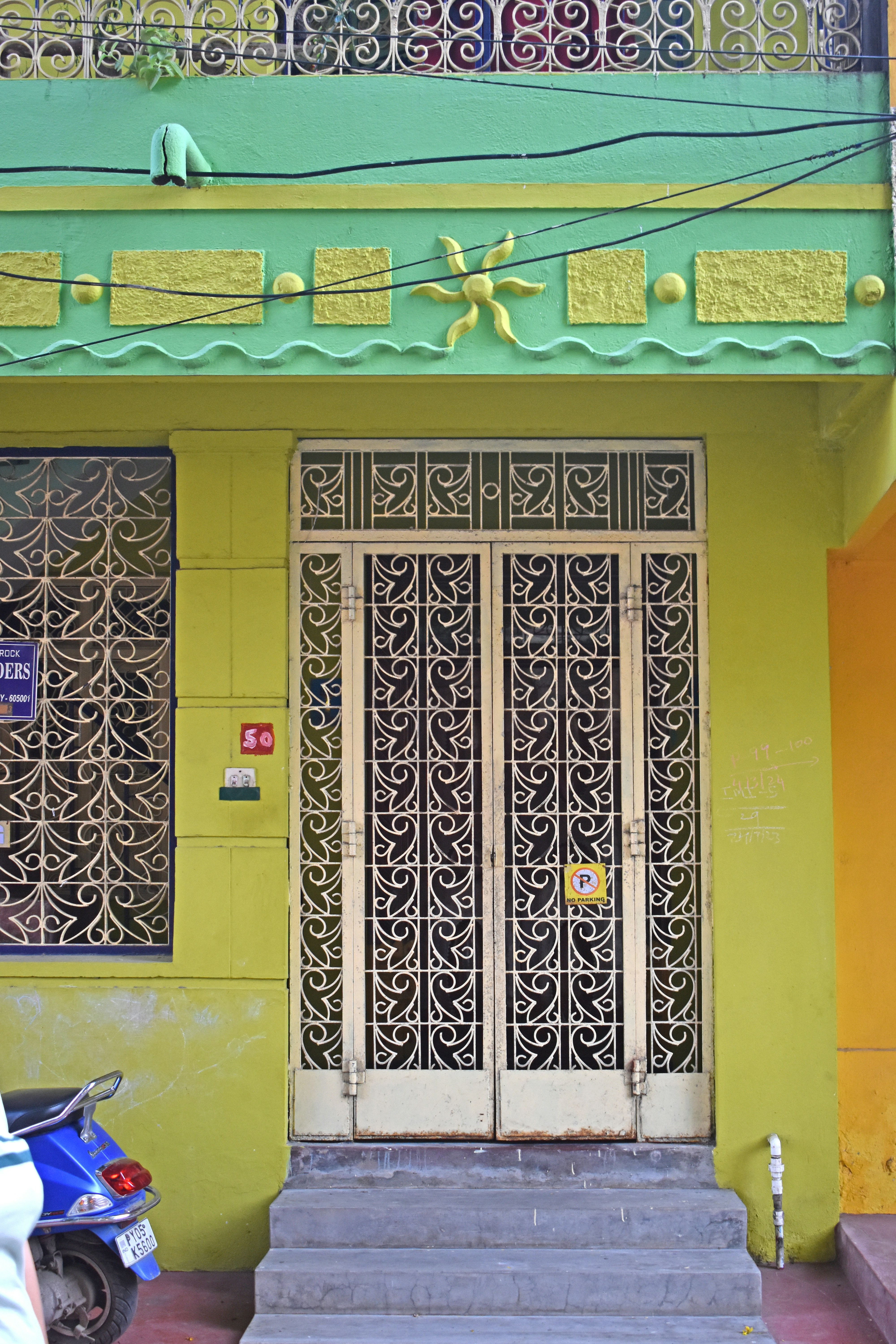 Lime-front doorway with ornate iron lace gate