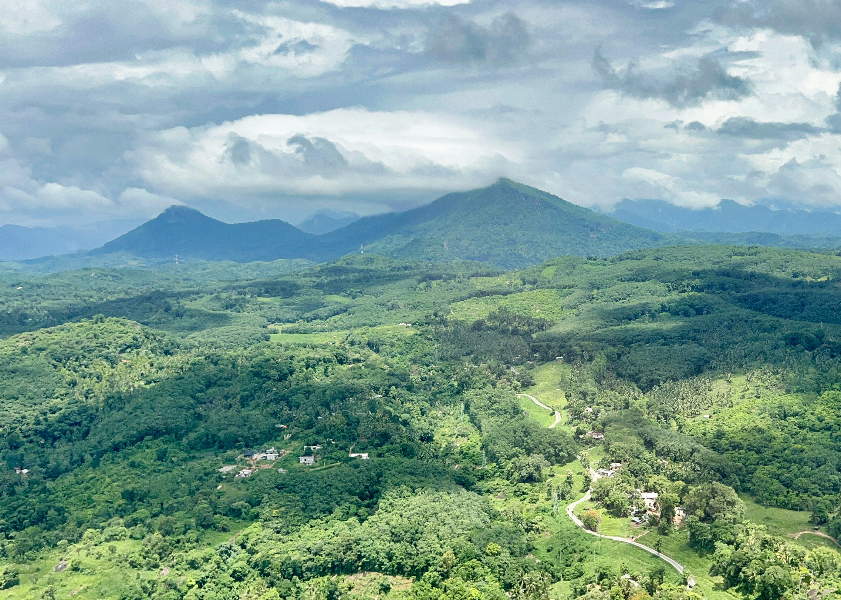 Lush green valleys and rolling hills stretch beneath a dramatic sky, showcasing the beauty of nature's landscape.