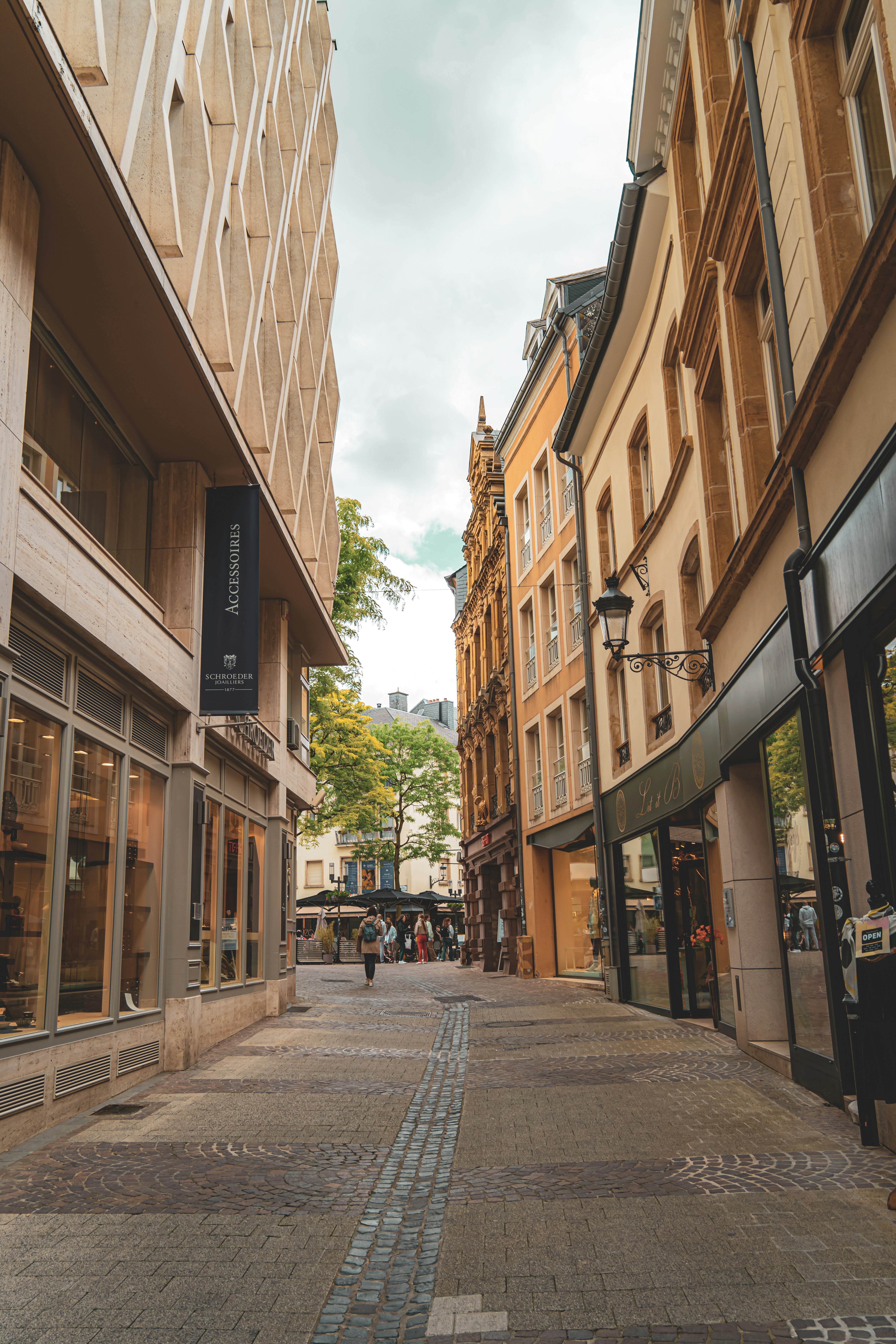 A narrow city street lined with tall buildings photo – Free City Image ...