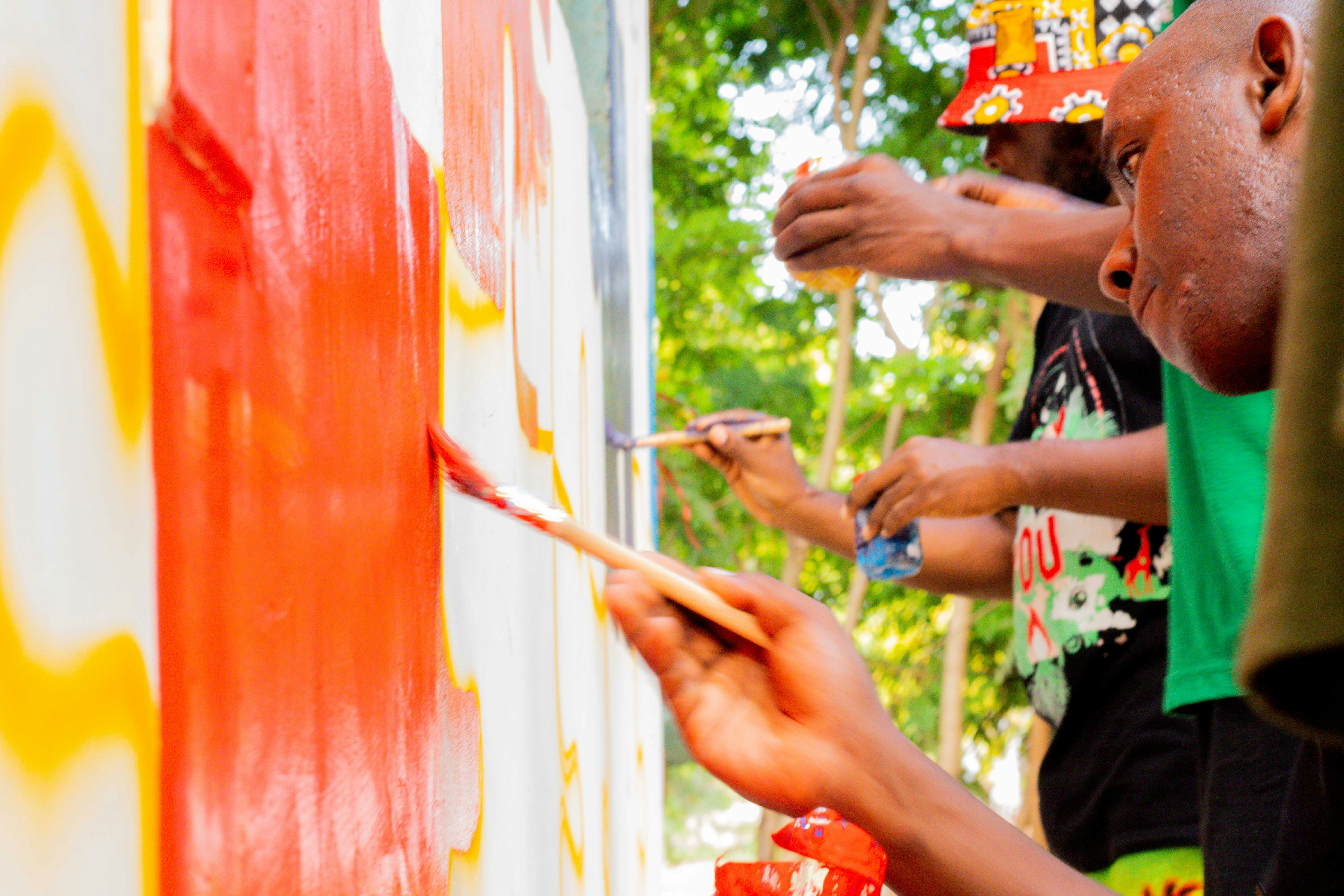 A group of people painting on a wall photo – Free Man Image on Unsplash