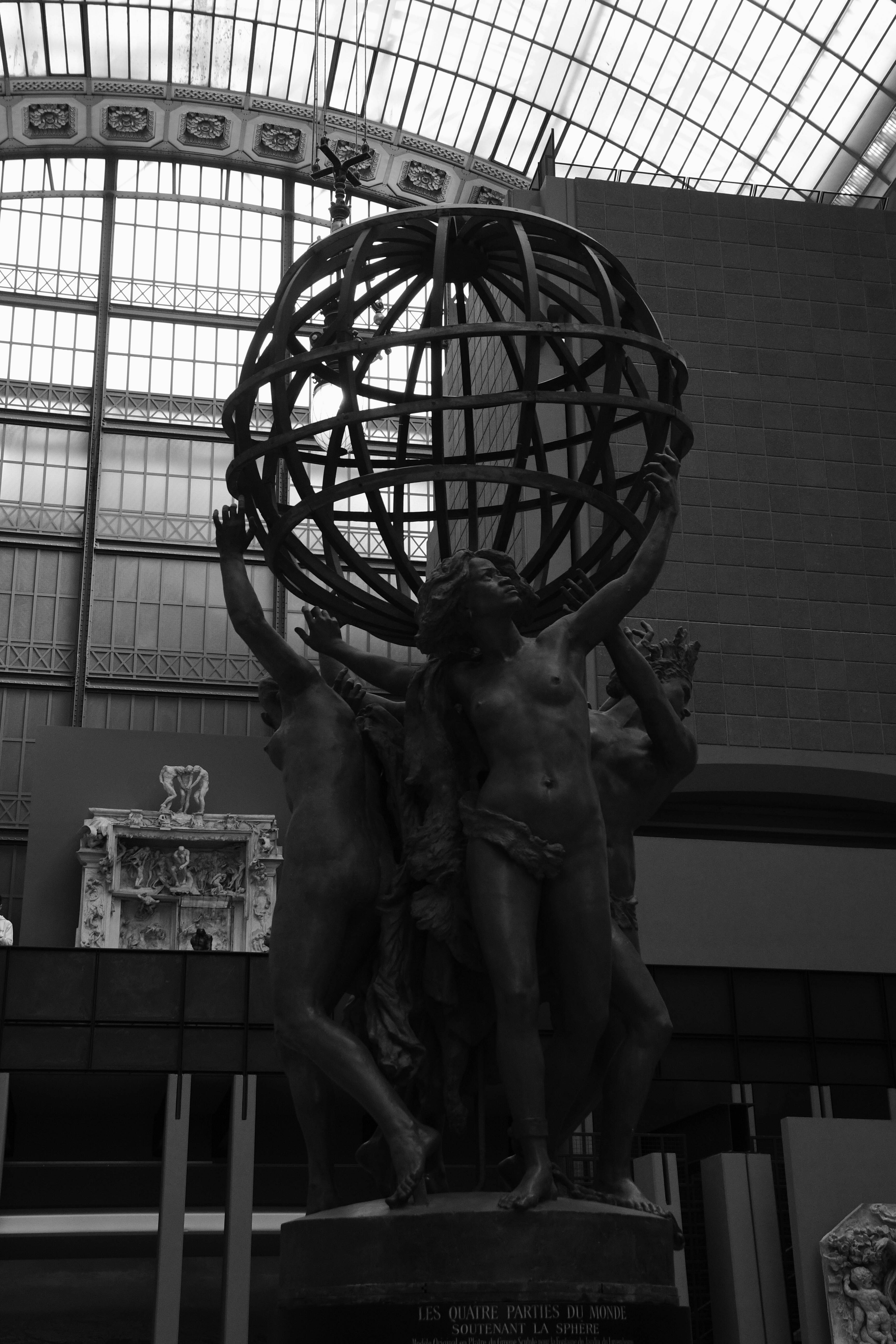 Globes of Gravity: Sculpted Youths Carry the World beneath a Glass Roof