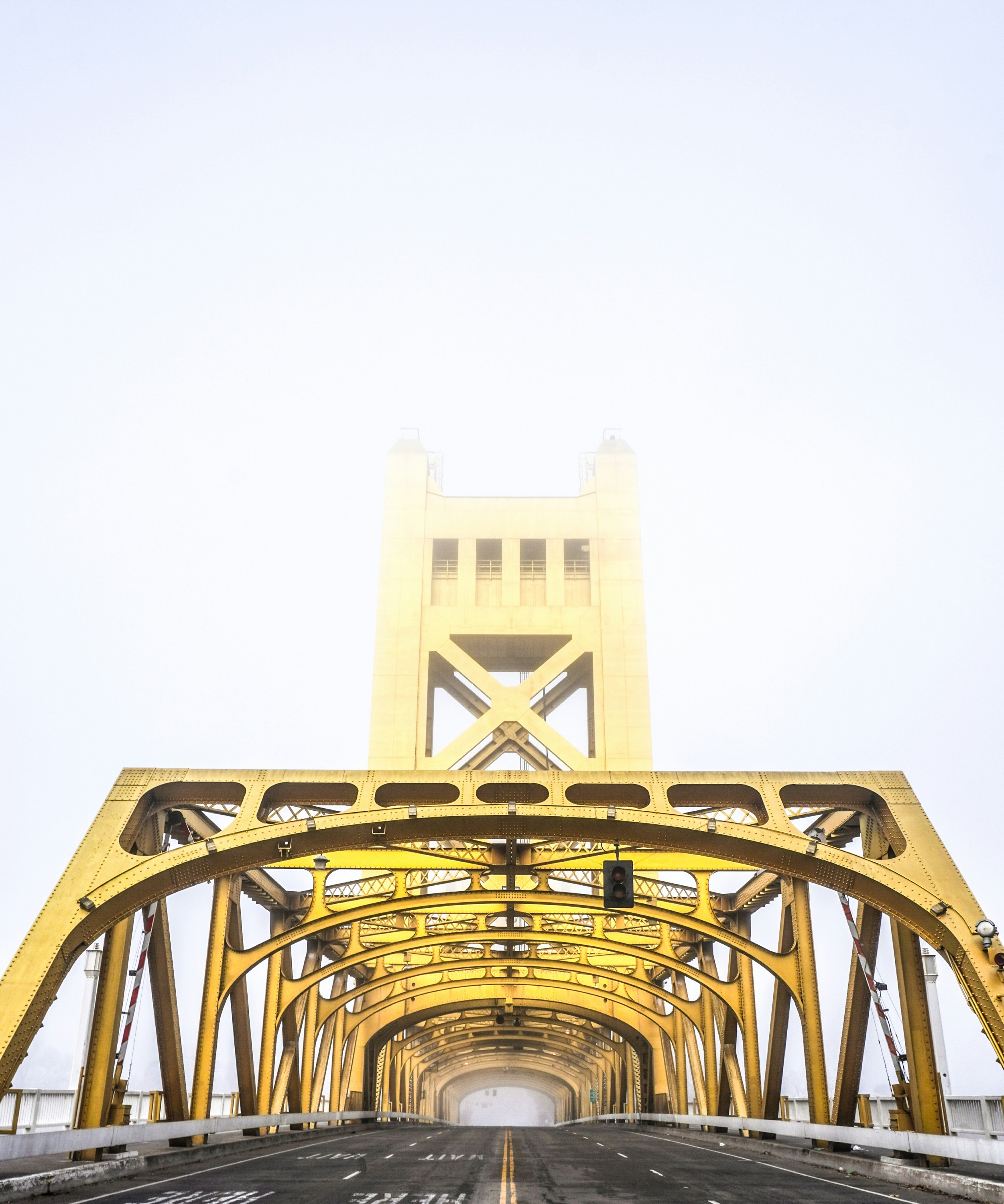 A yellow bridge with a clock tower in the background photo – Free ...