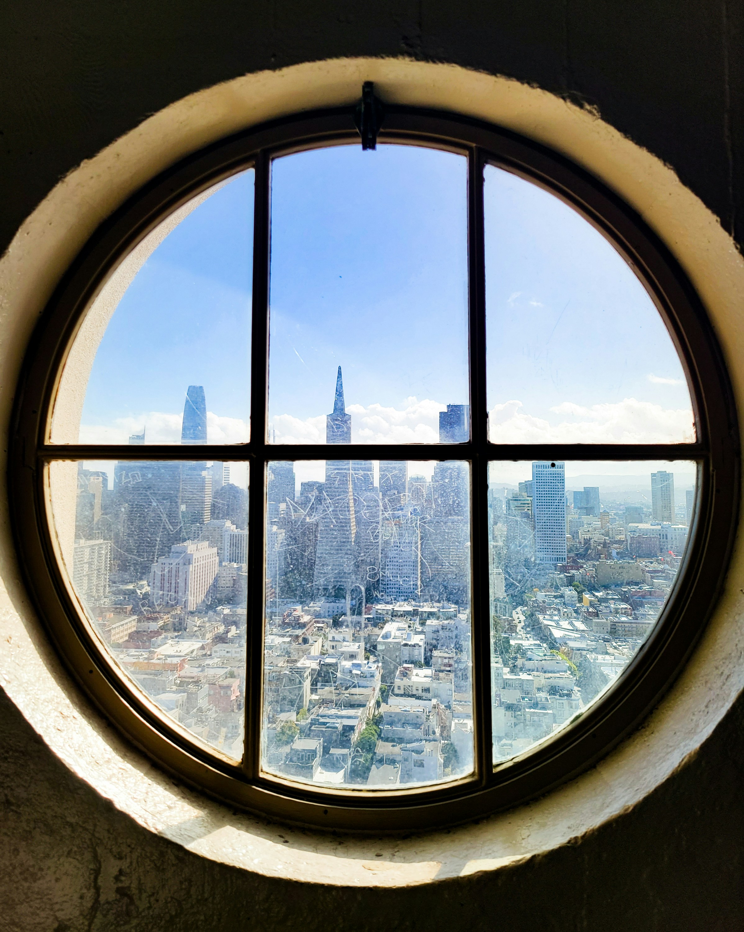A round window with a view of a city photo – Free Window Image on Unsplash
