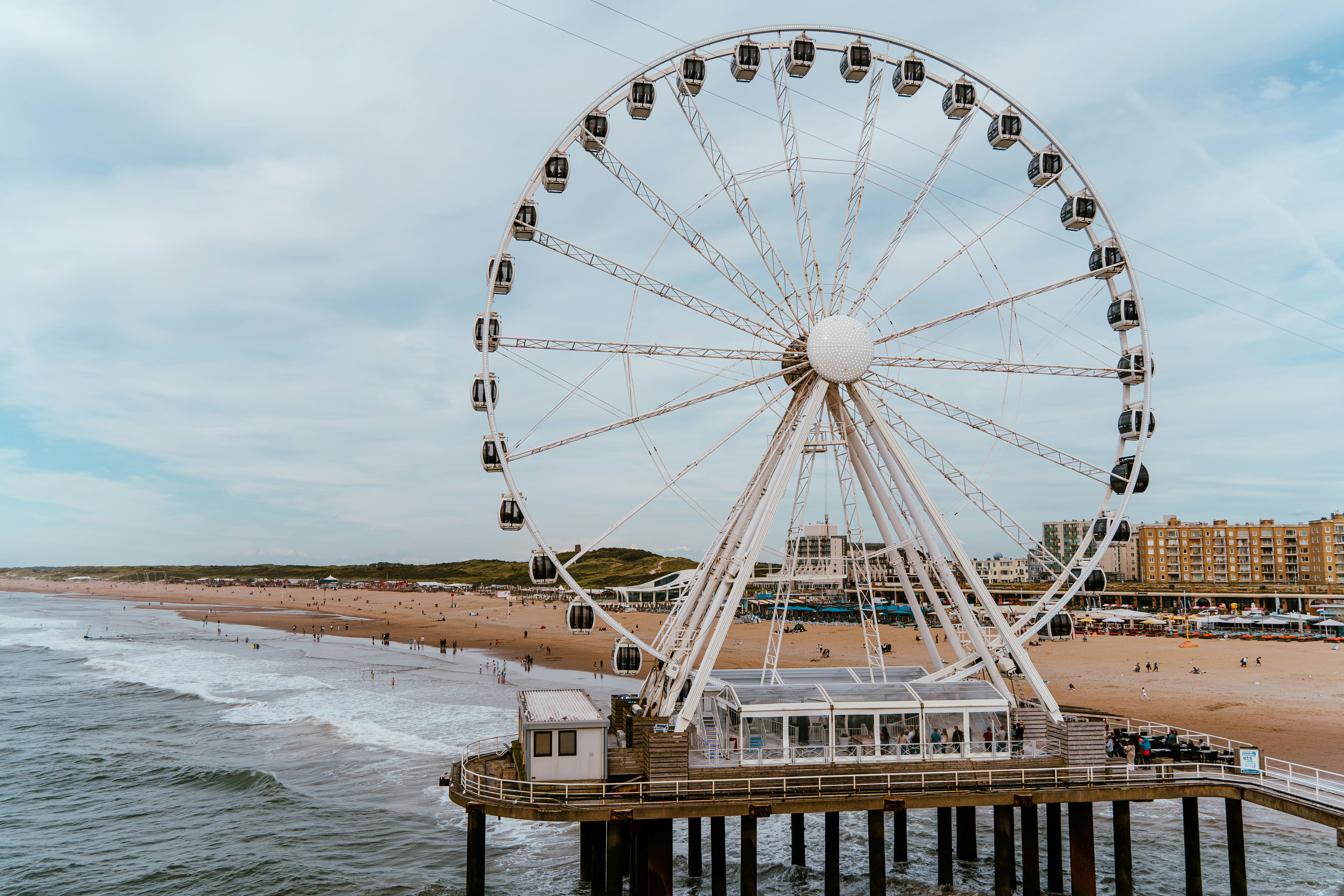 A ferris wheel sitting on top of a pier next to the ocean photo – Free ...
