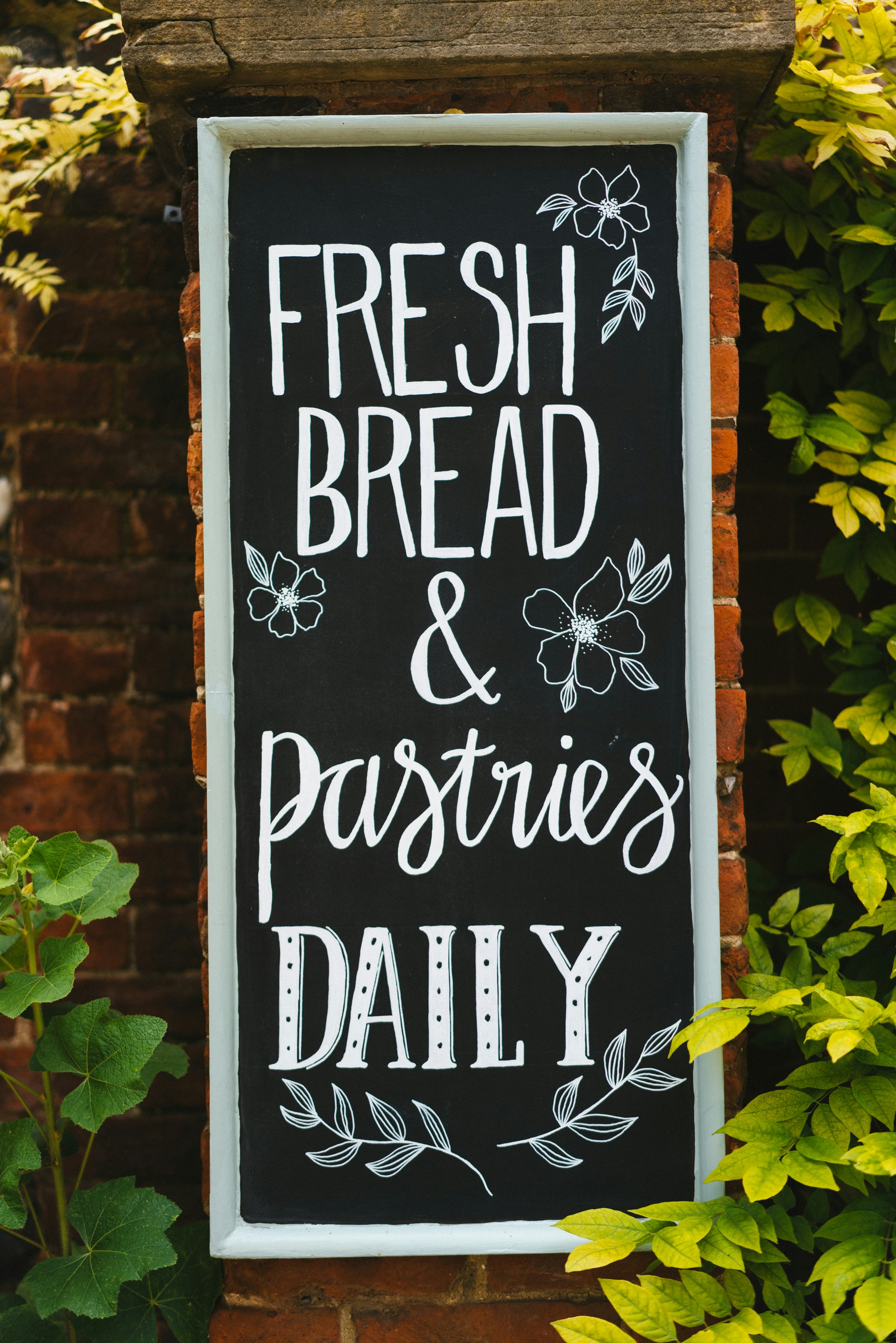 Fresh Bread & Pastries Daily: Chalkboard Sign in a Brick Wall Morning
