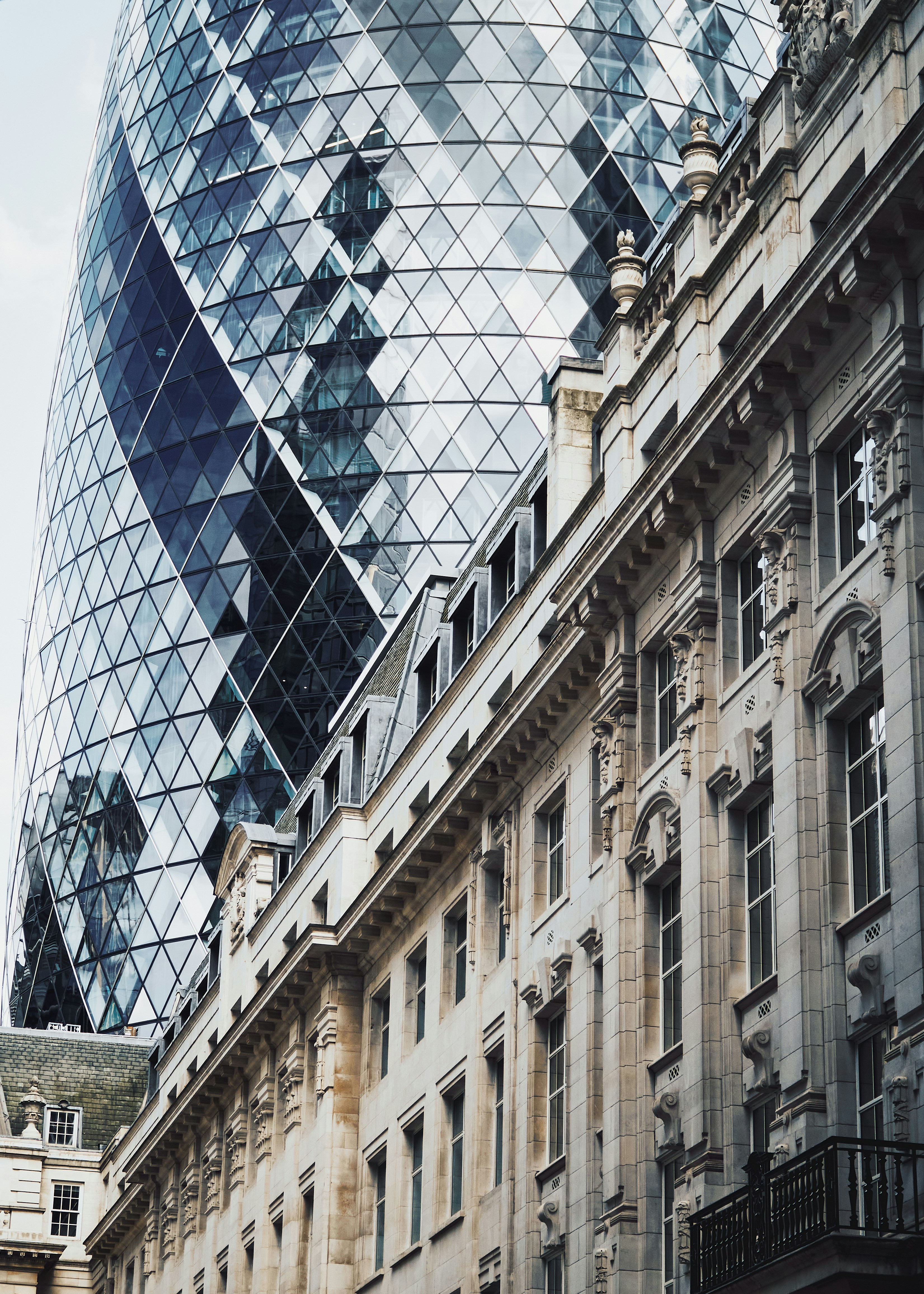 Contrasting Facades: Modern Glass Angles Beside Historic Stone
