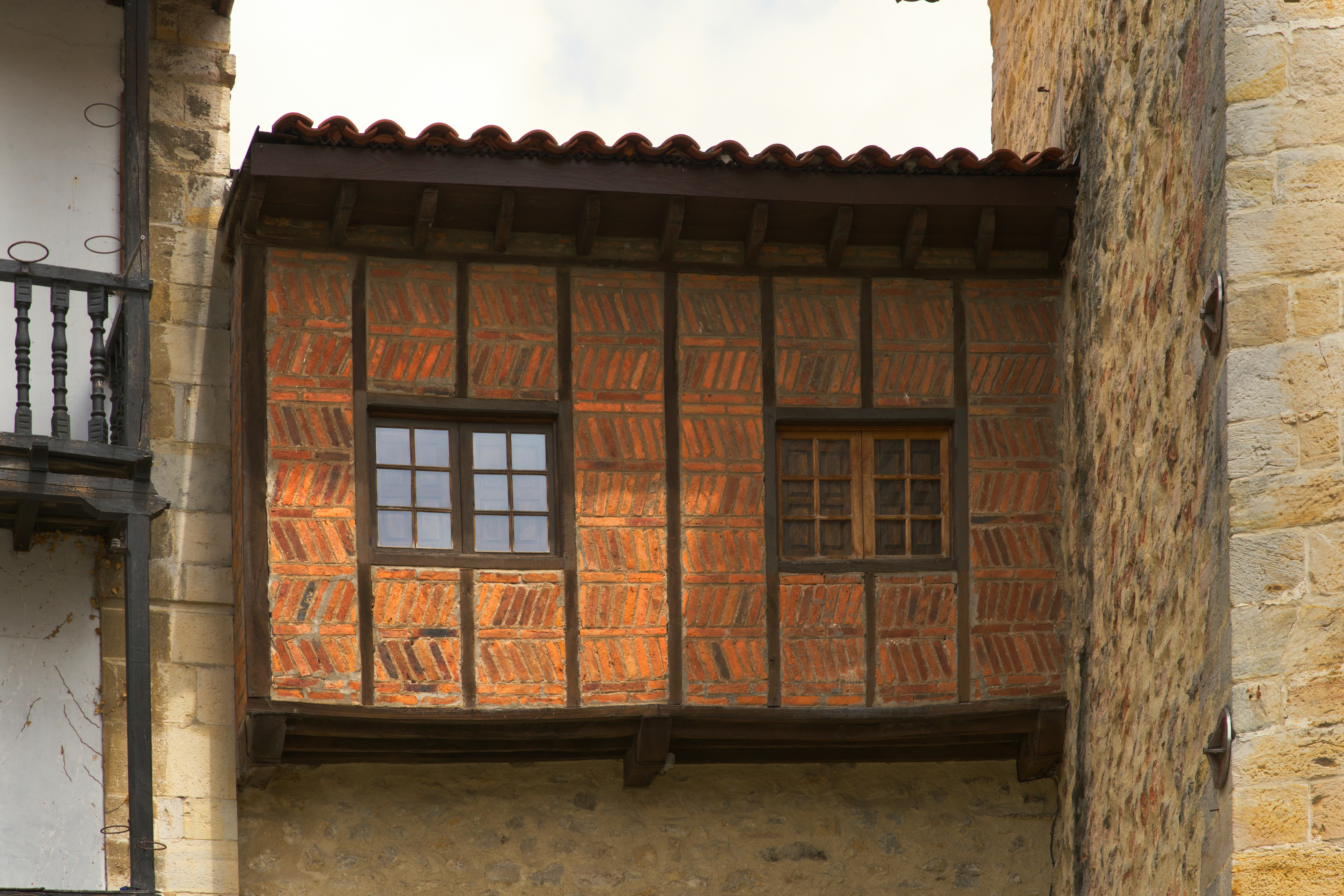 Cantilevered Timber Crown Over Stone Facade
