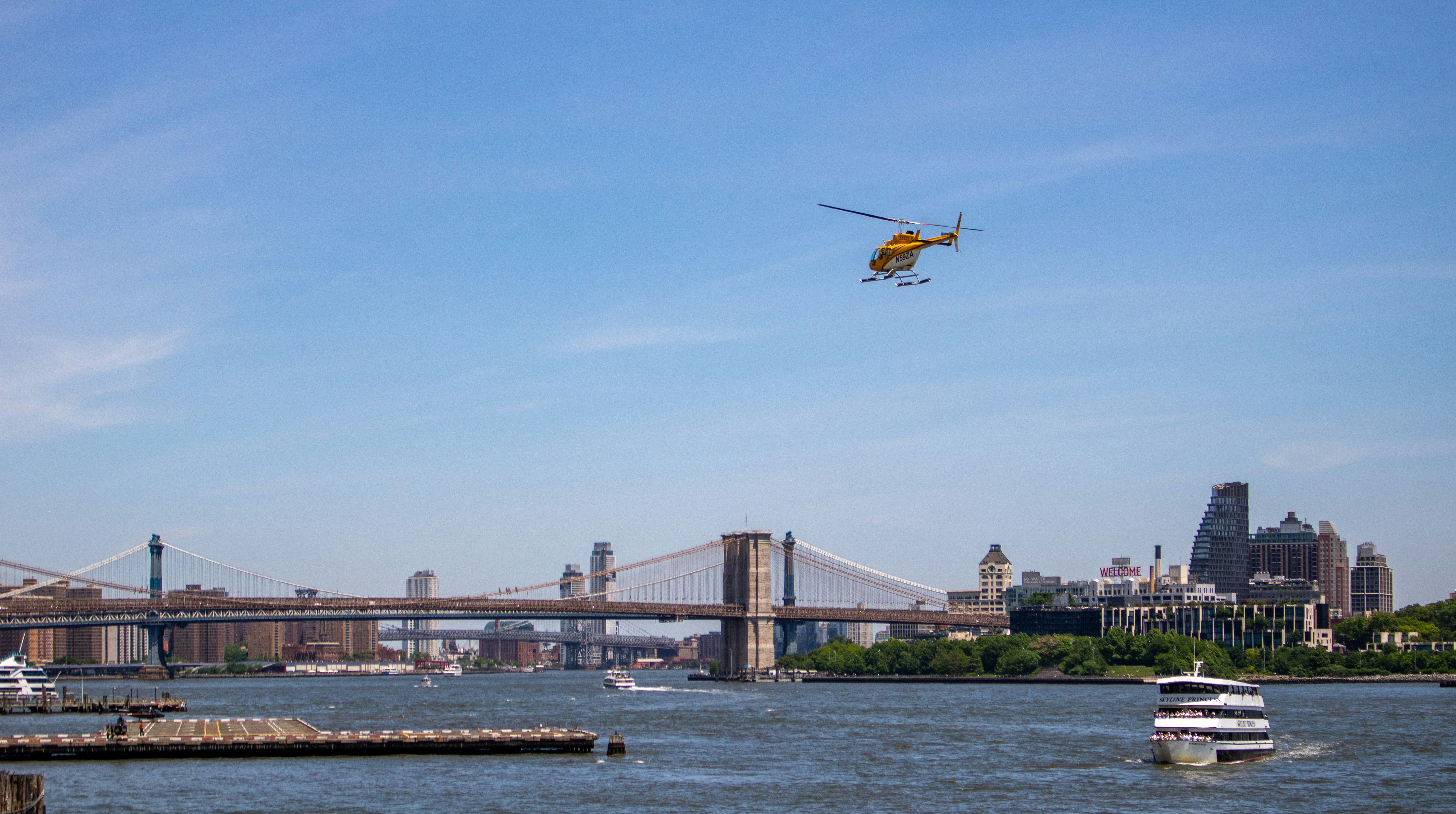 Photographed here are Manhattan Bridge and Brooklyn Bridge over the East River | A helicopter flying over a body of water