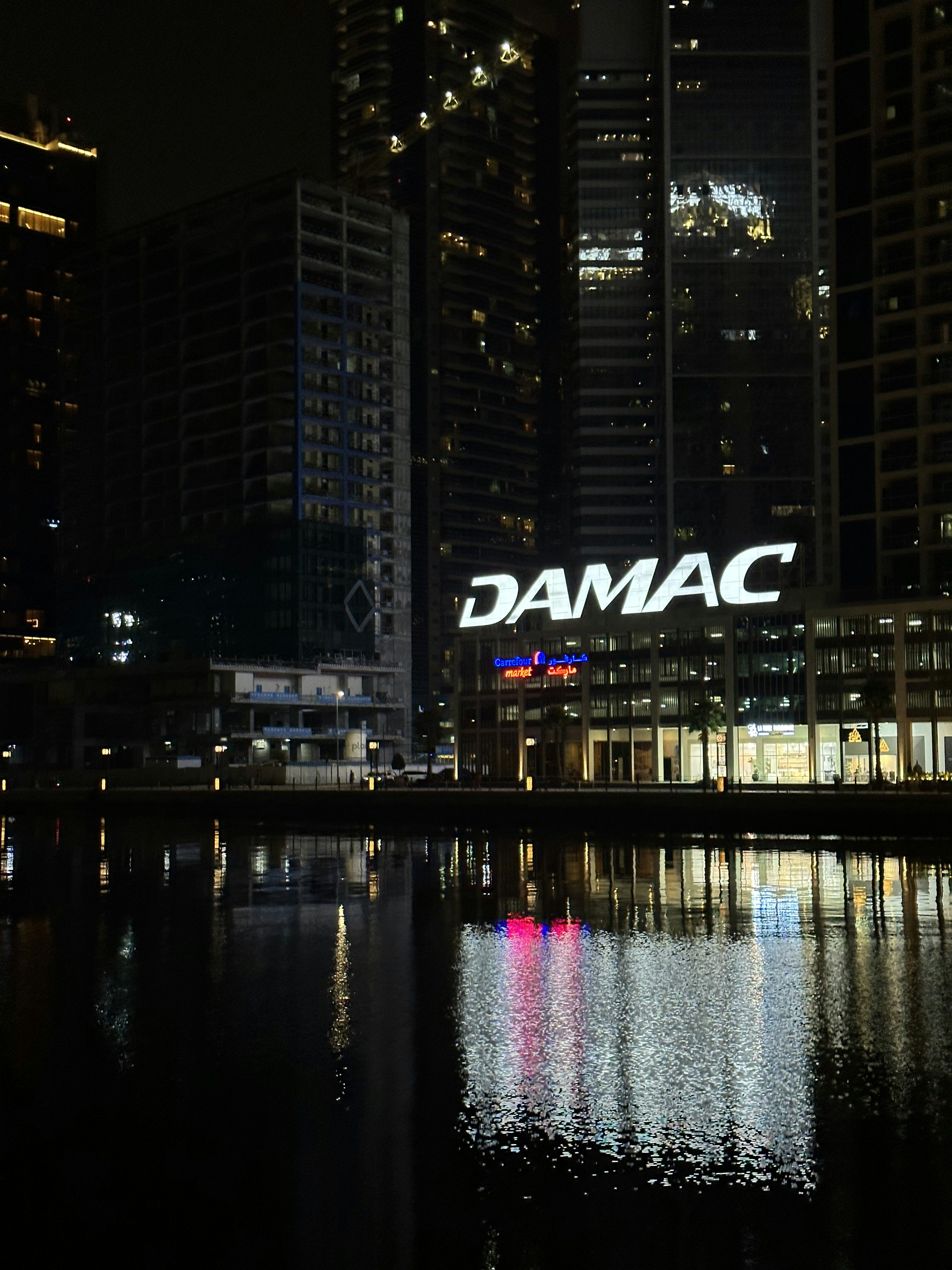A view of a city at night with a sign that says damac photo – Free ...