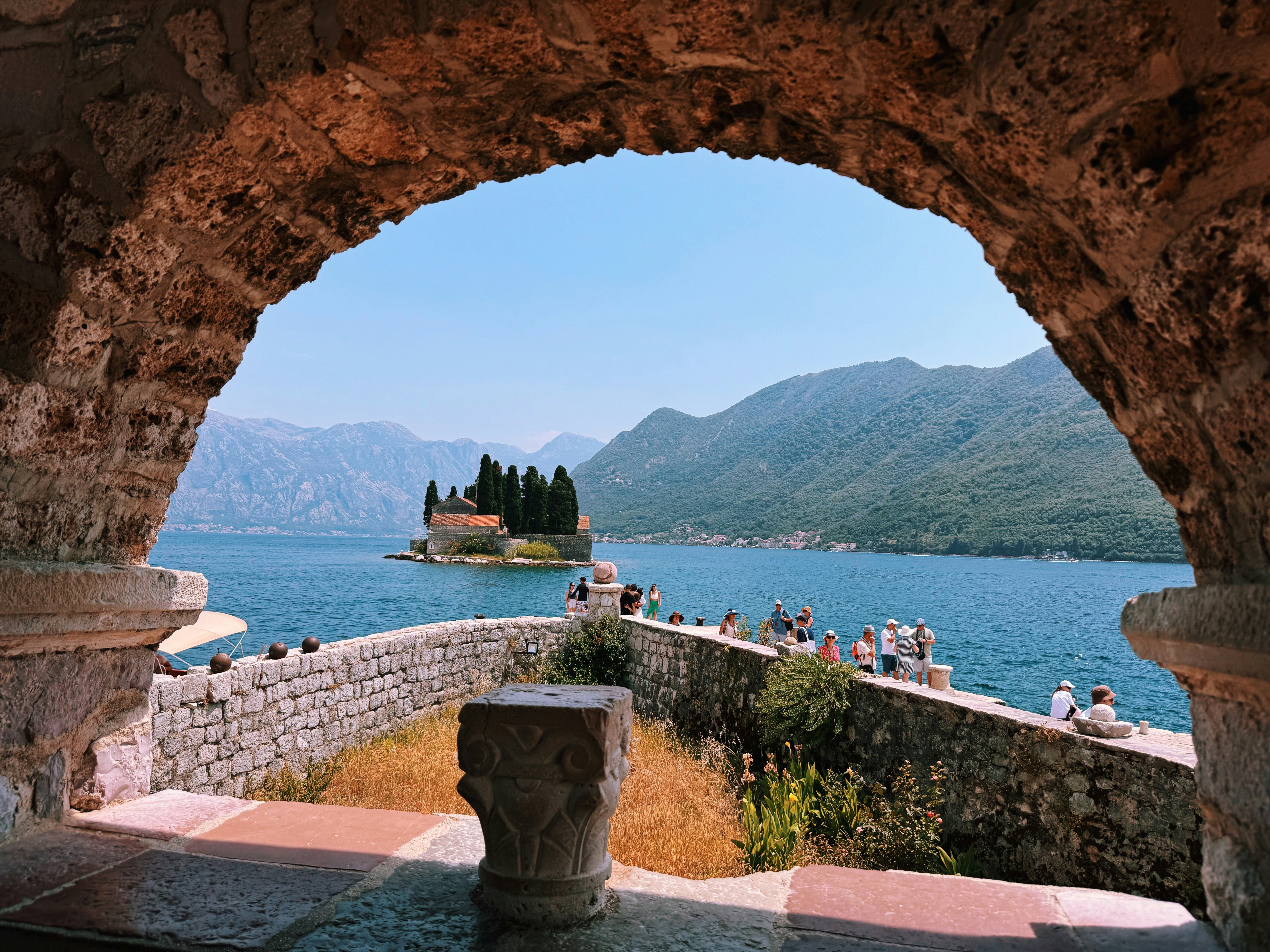 A view of a body of water through a stone archway photo – Free Perast ...