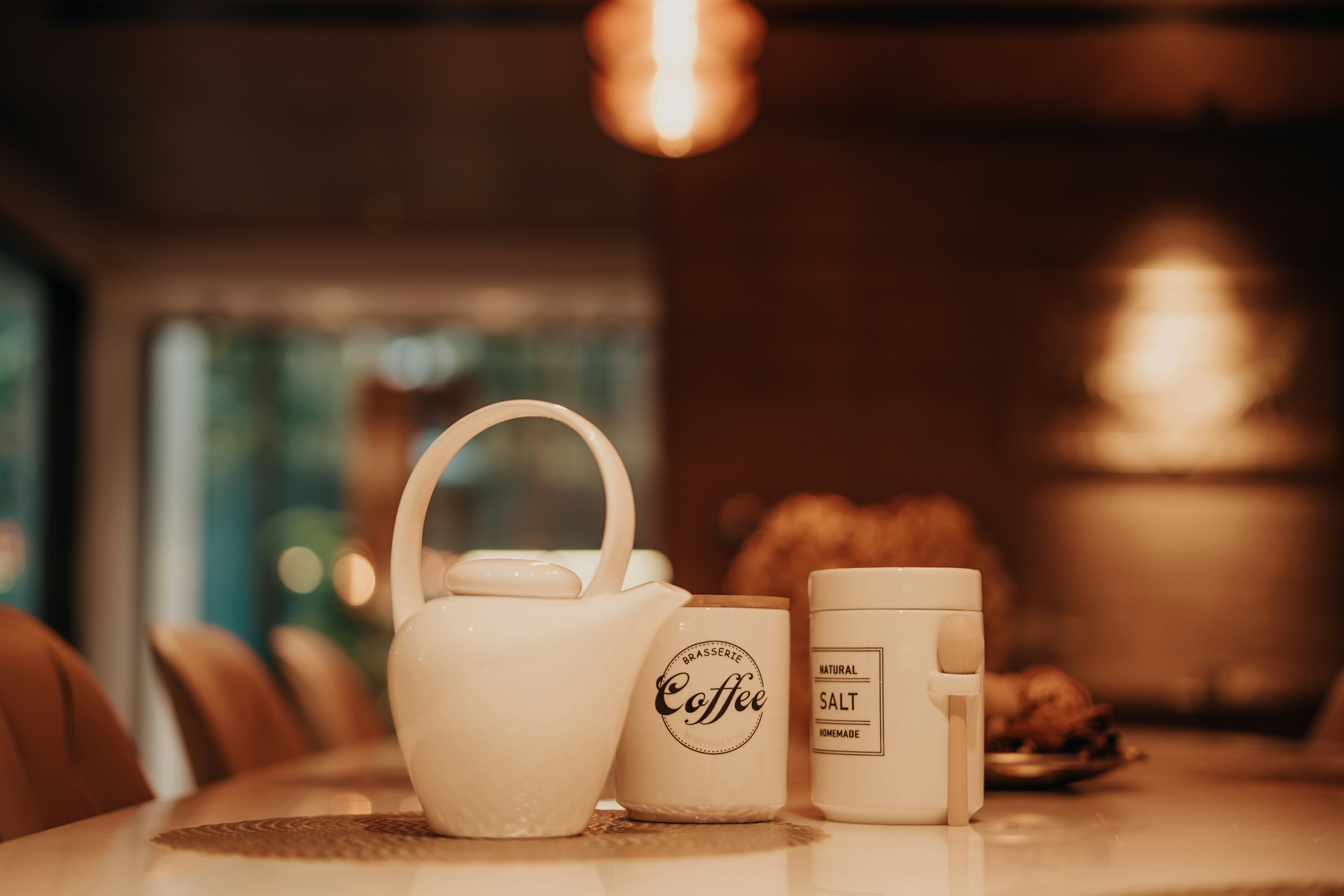 Amber Still Life: White Teapot Framed by Coffee Jars on a Café Counter