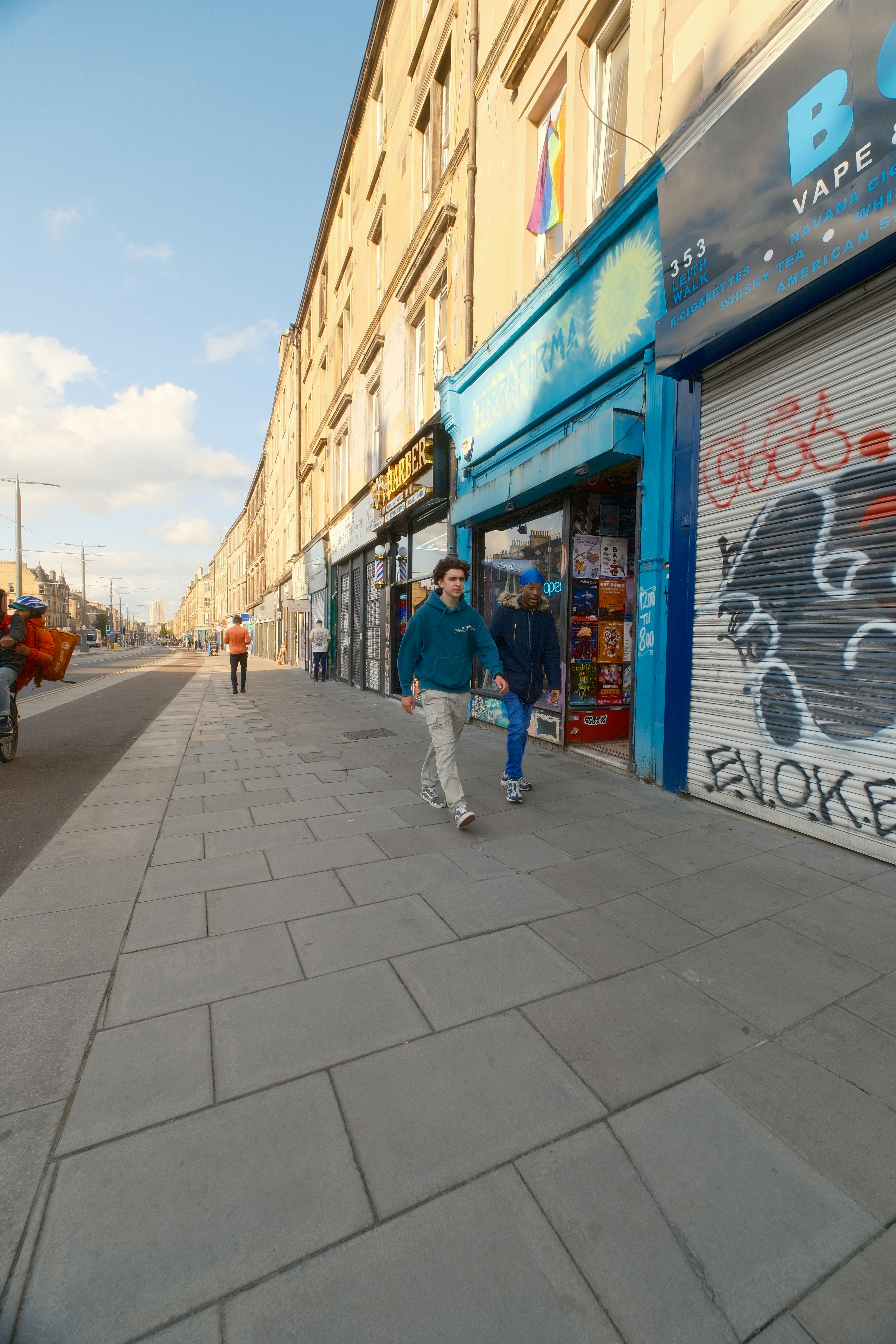 City Street Walk: Two Friends Step Out of a Blue Shopfront