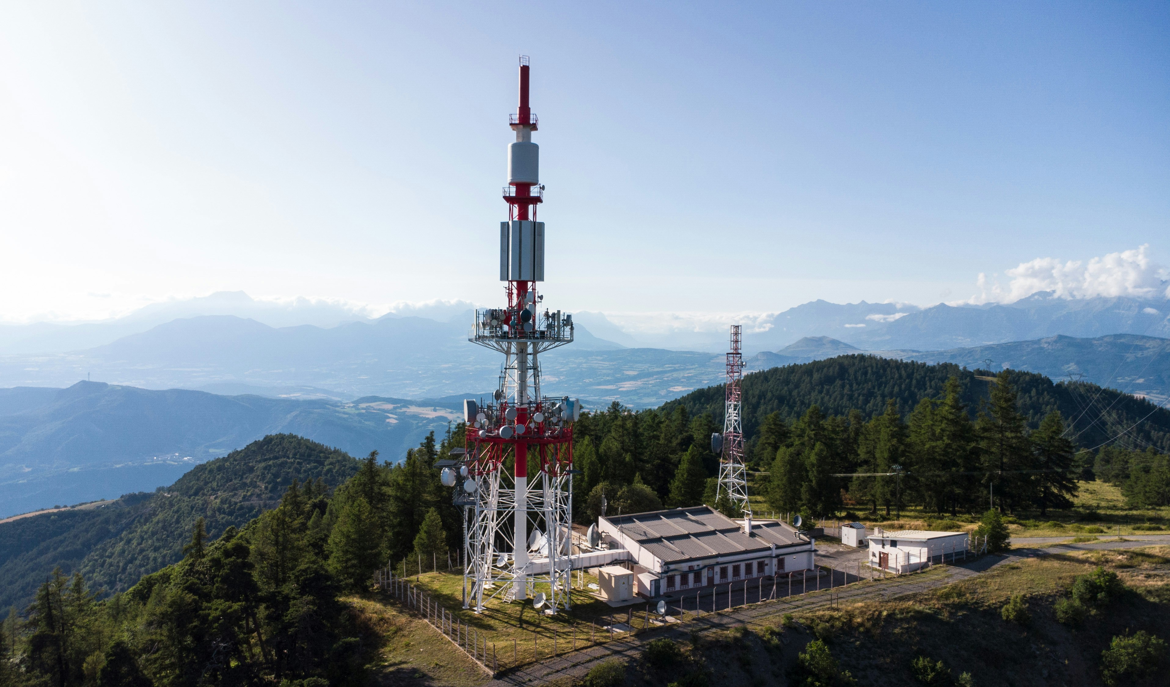 A very tall tower sitting on top of a lush green hillside