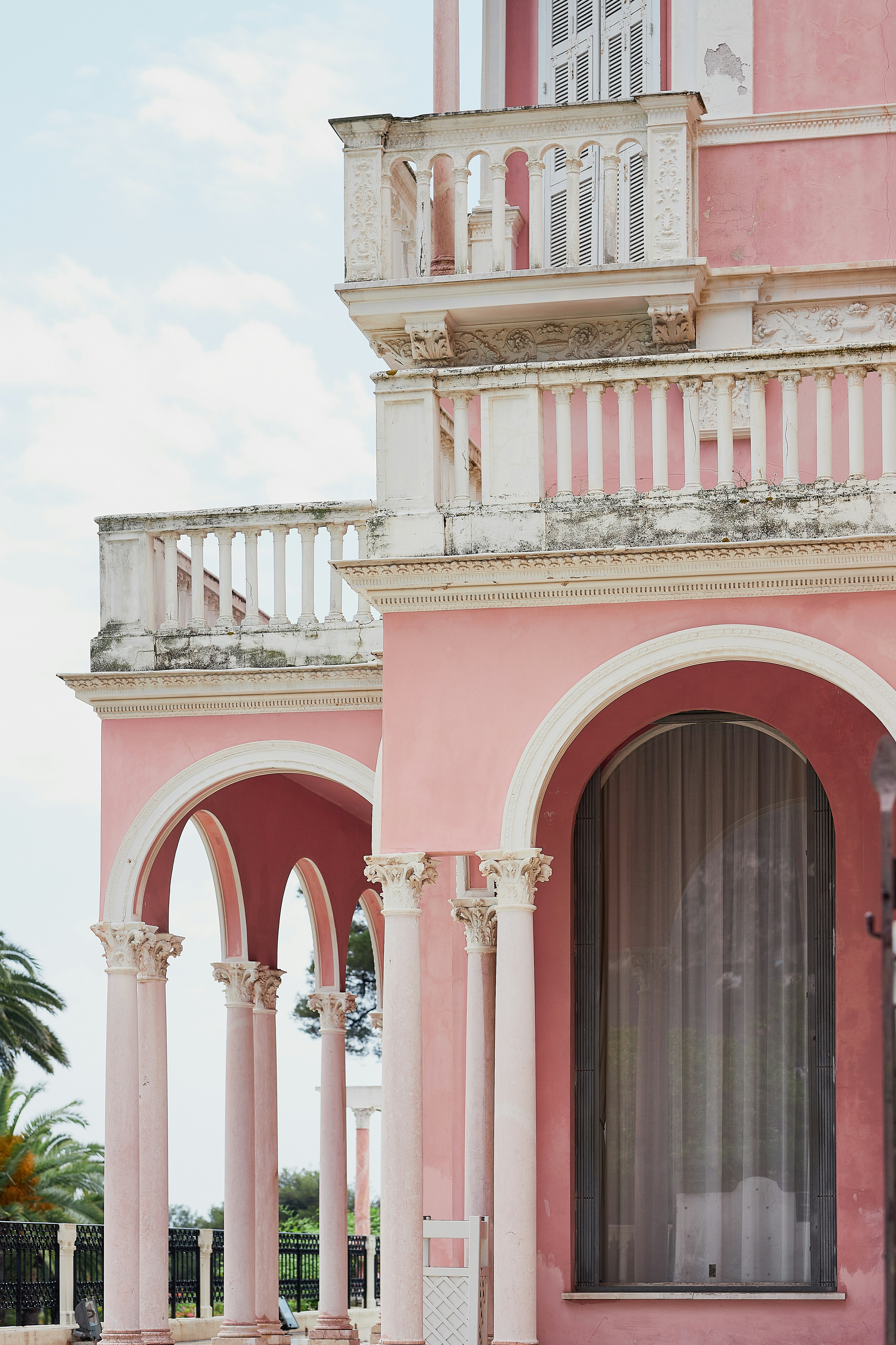 A pink building with columns and a clock tower photo – Free Villa ...