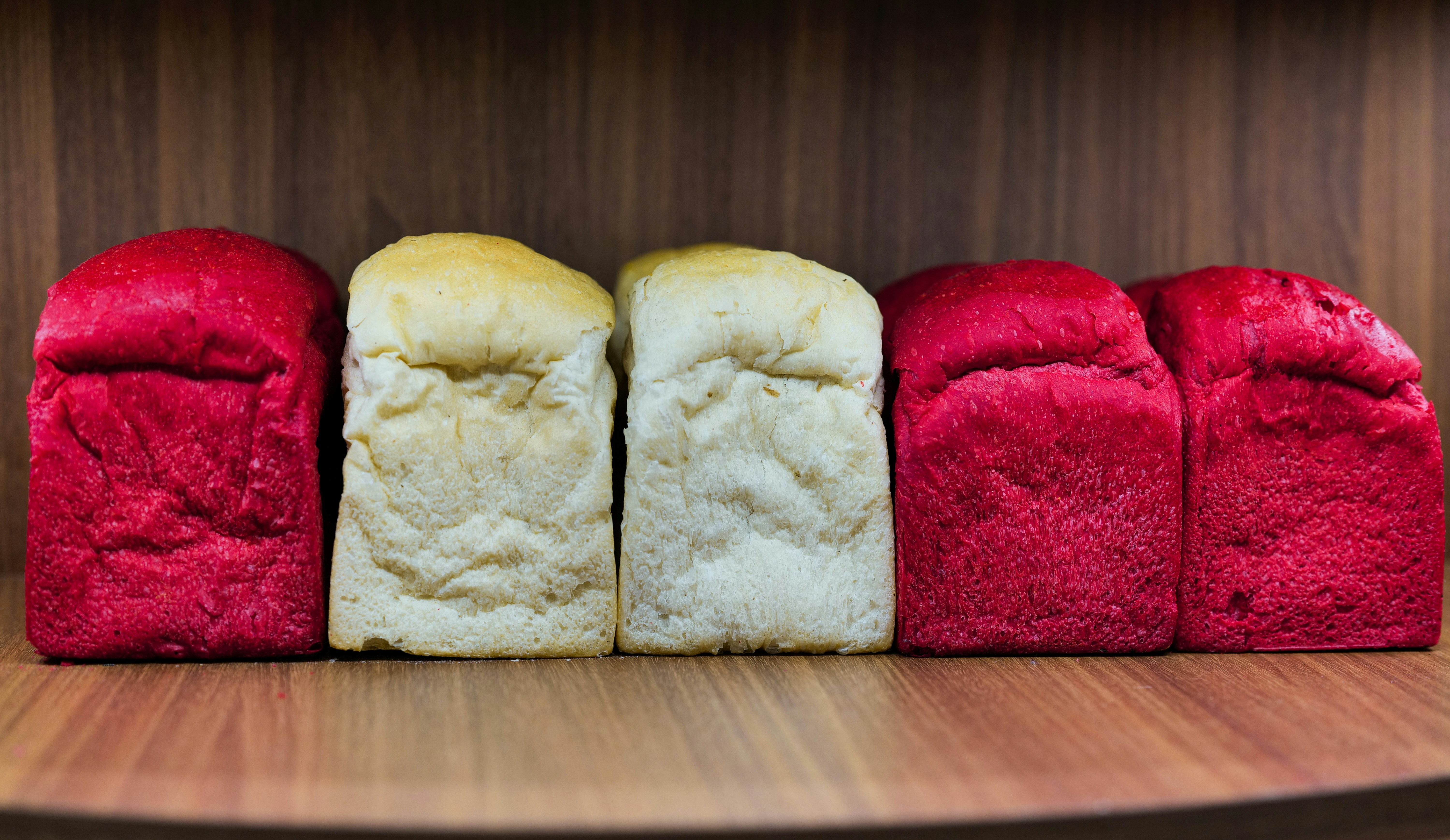 A row of red and white bread on a wooden shelf photo – Free Pudong ...