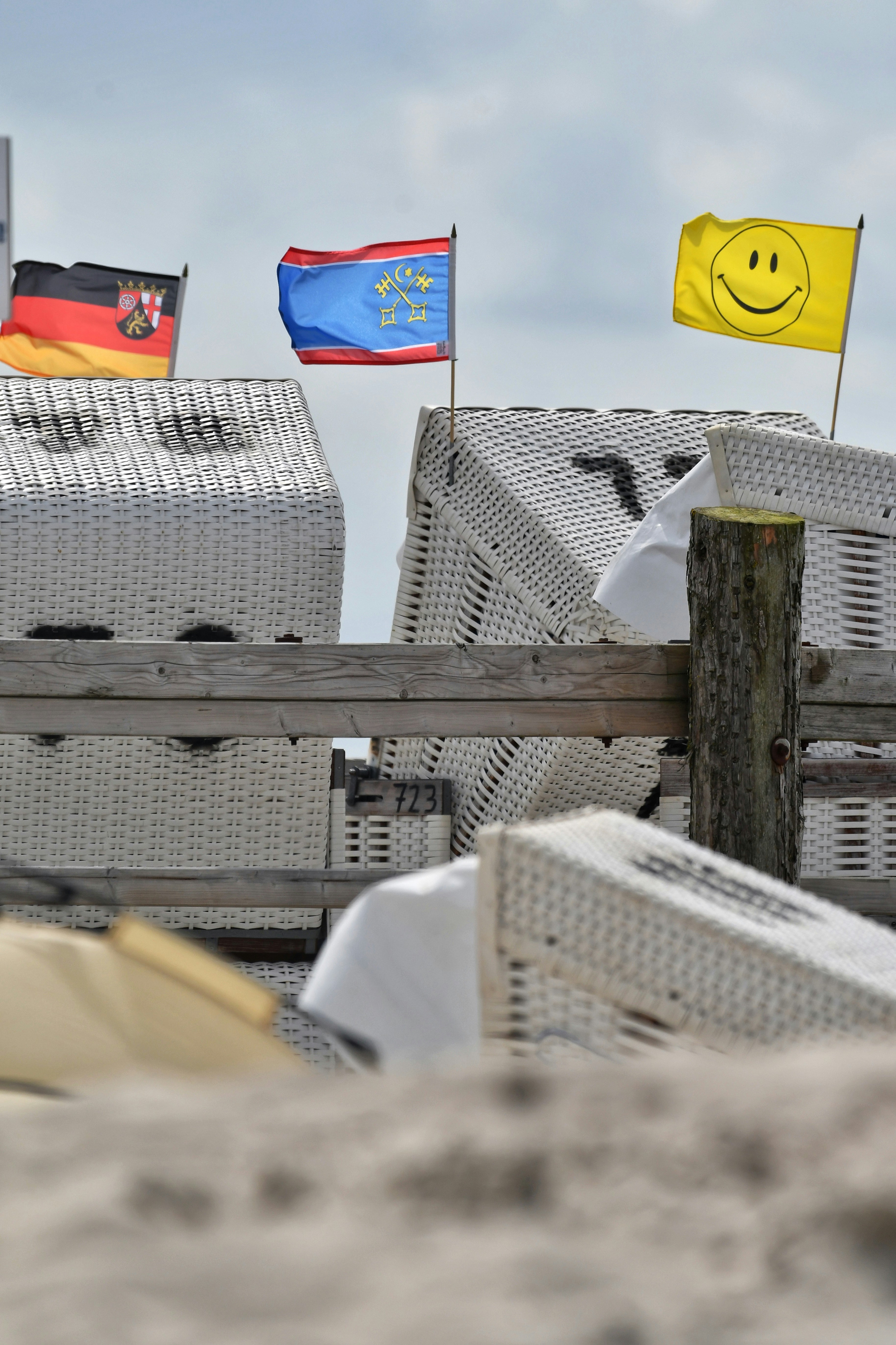 Seaside Flags Above Wicker Loungers: A Sunlit Moment of Color and Texture