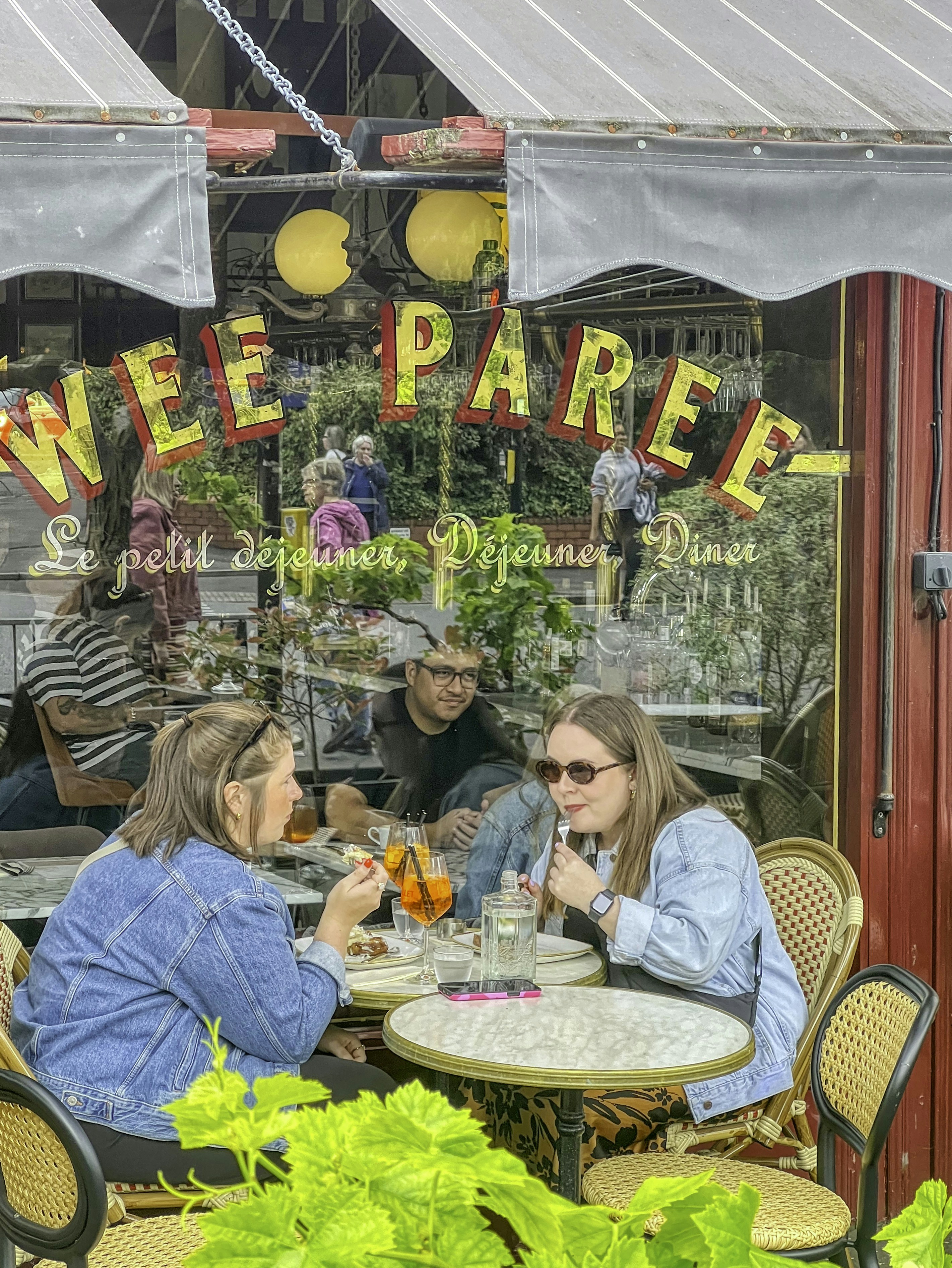 Glass-Walled Café Chats on a Parisian Terrace