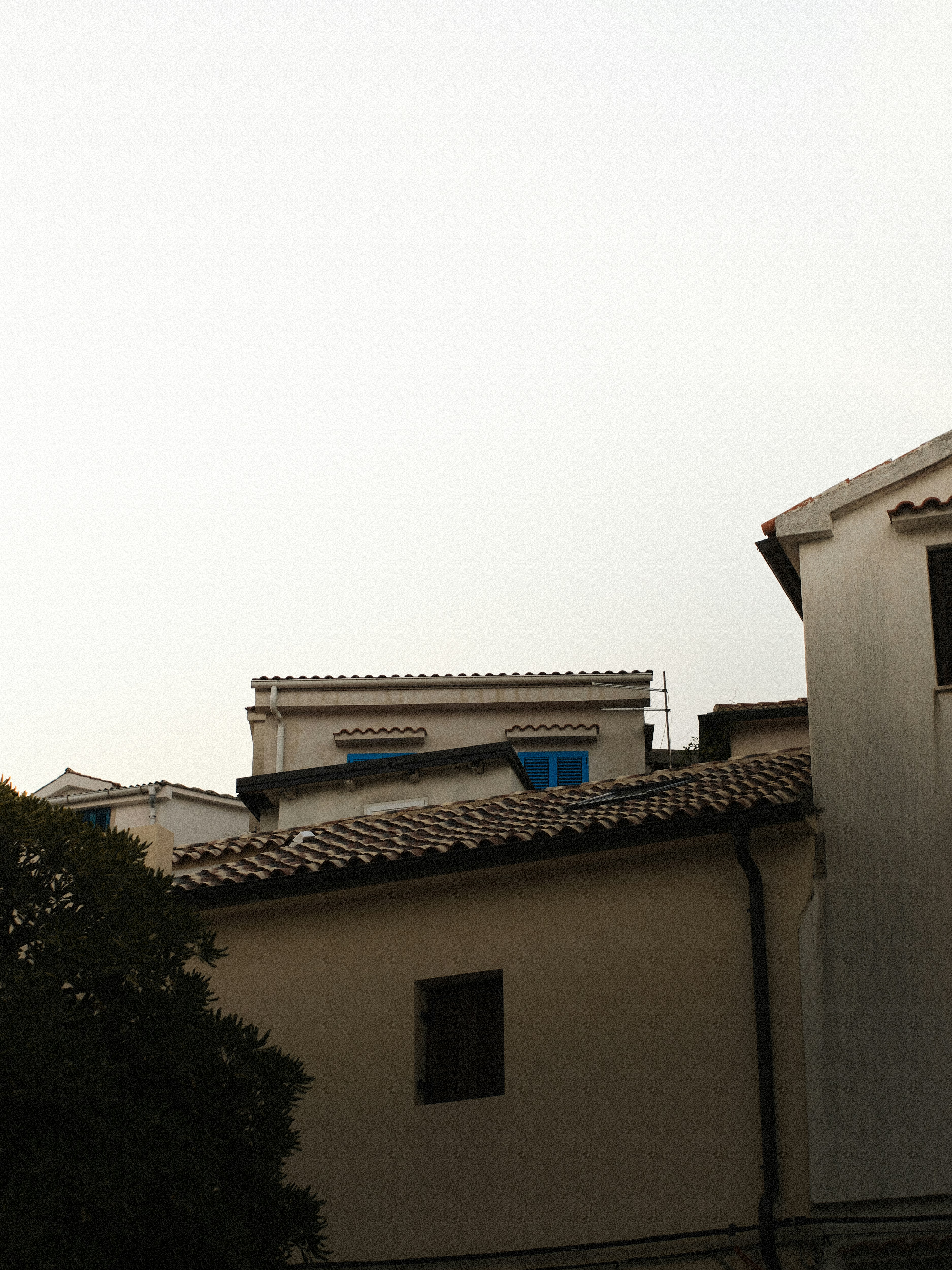 Blue Window Between Terracotta Rooflines