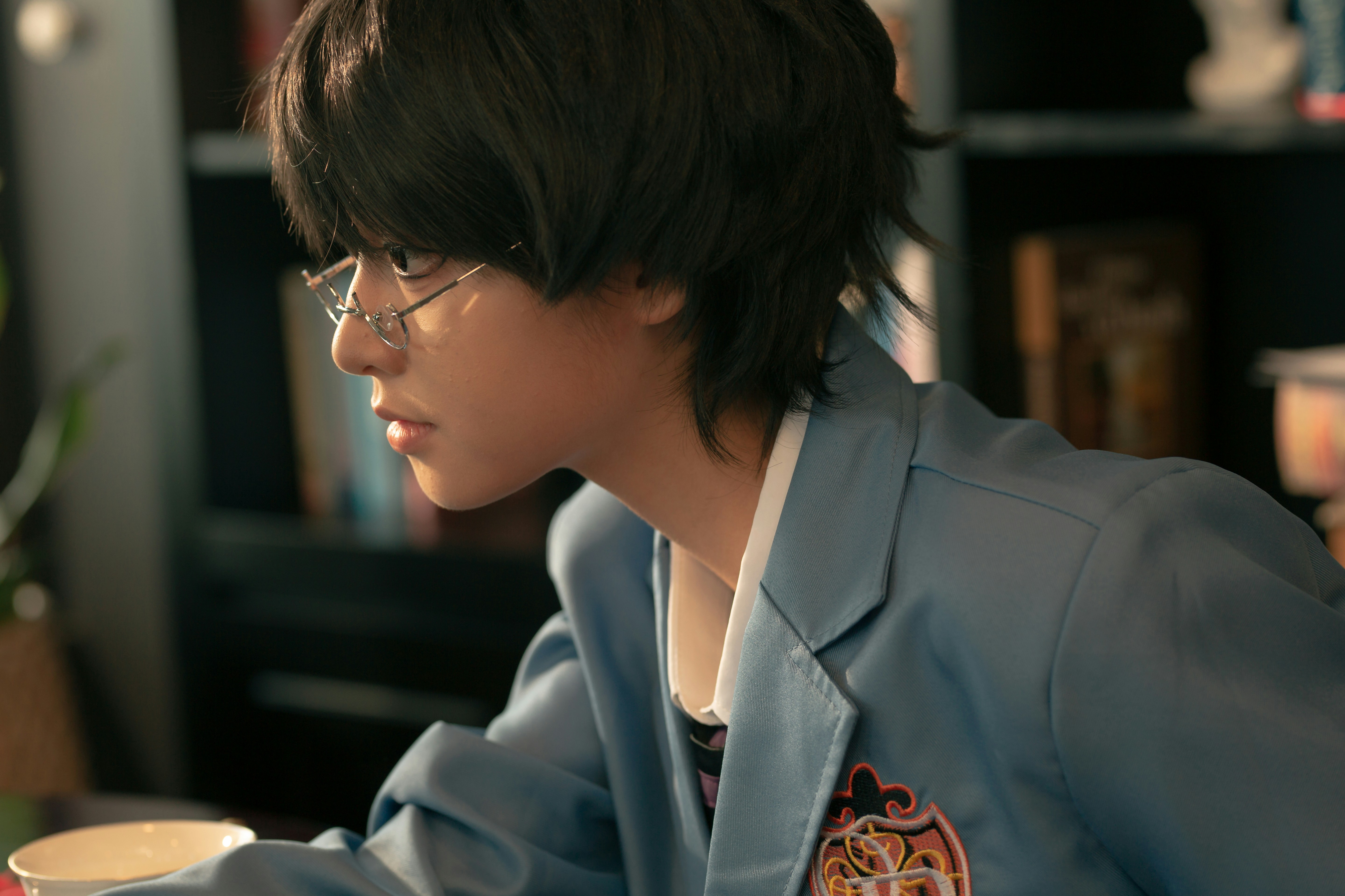 A young man sitting at a desk using a laptop computer photo – Free ...