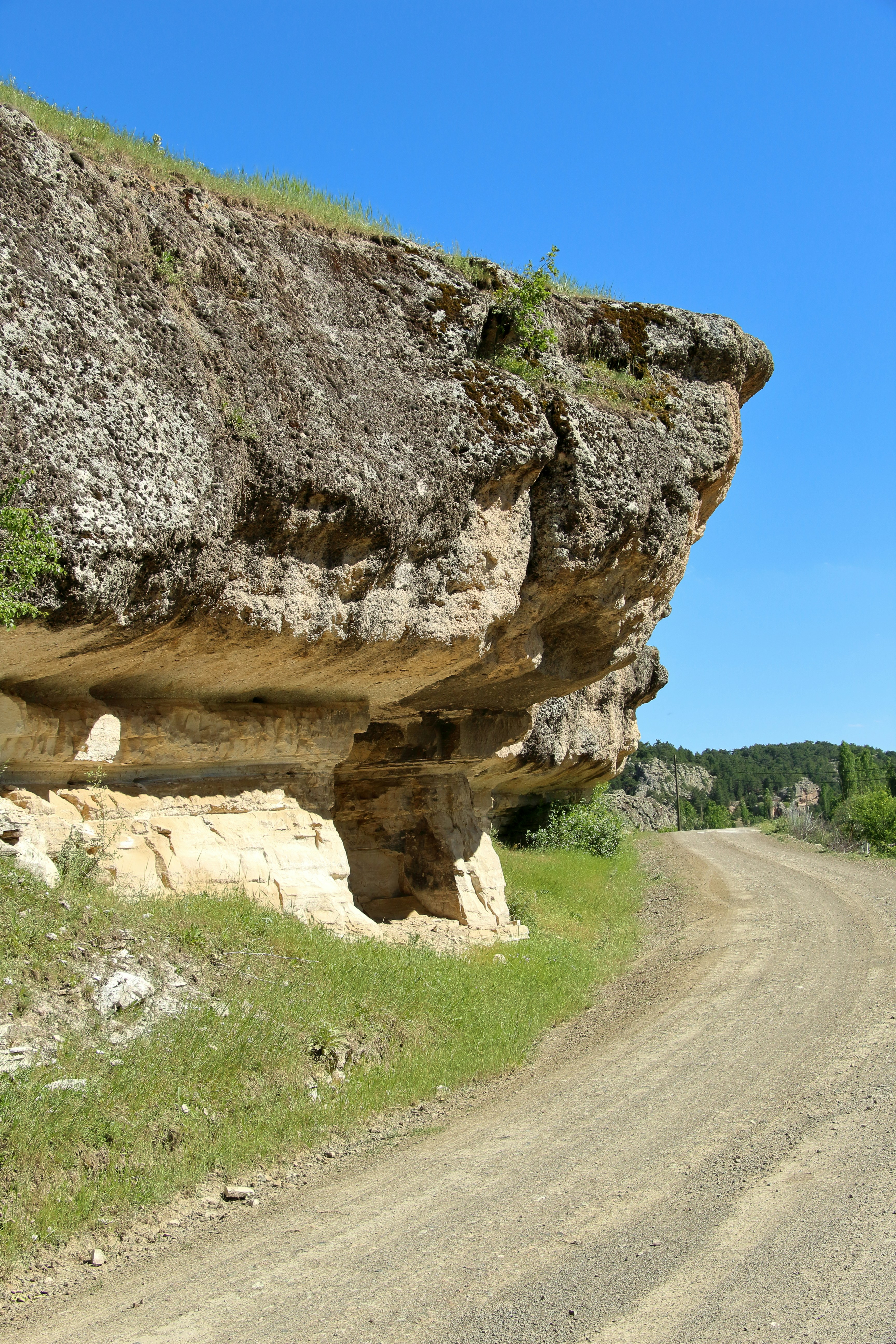 Limestone Overhang by the Dusty Road: Sunlit Strata and Open Sky