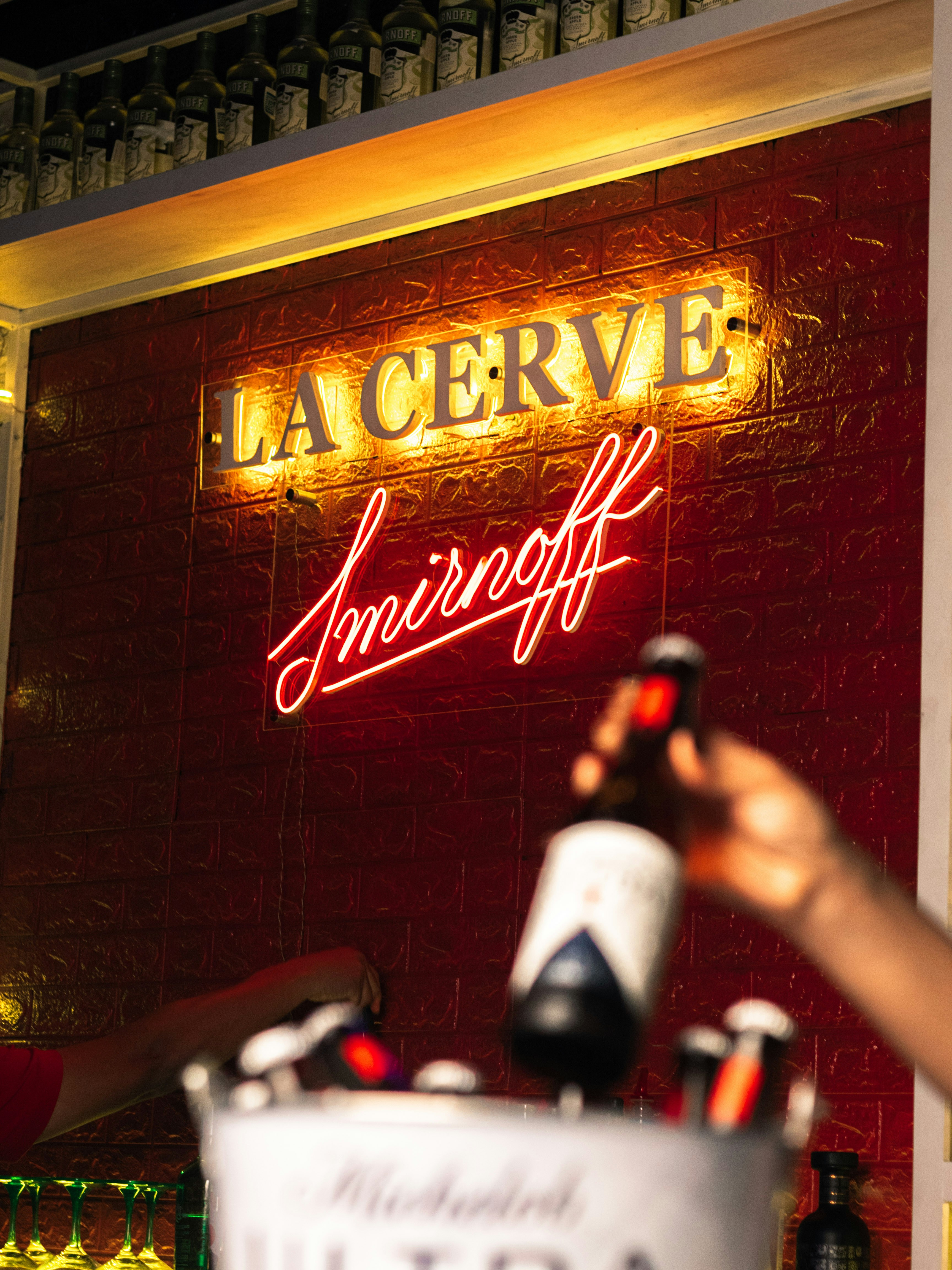 Neon Sign Pulse Over a Toast of Bottles