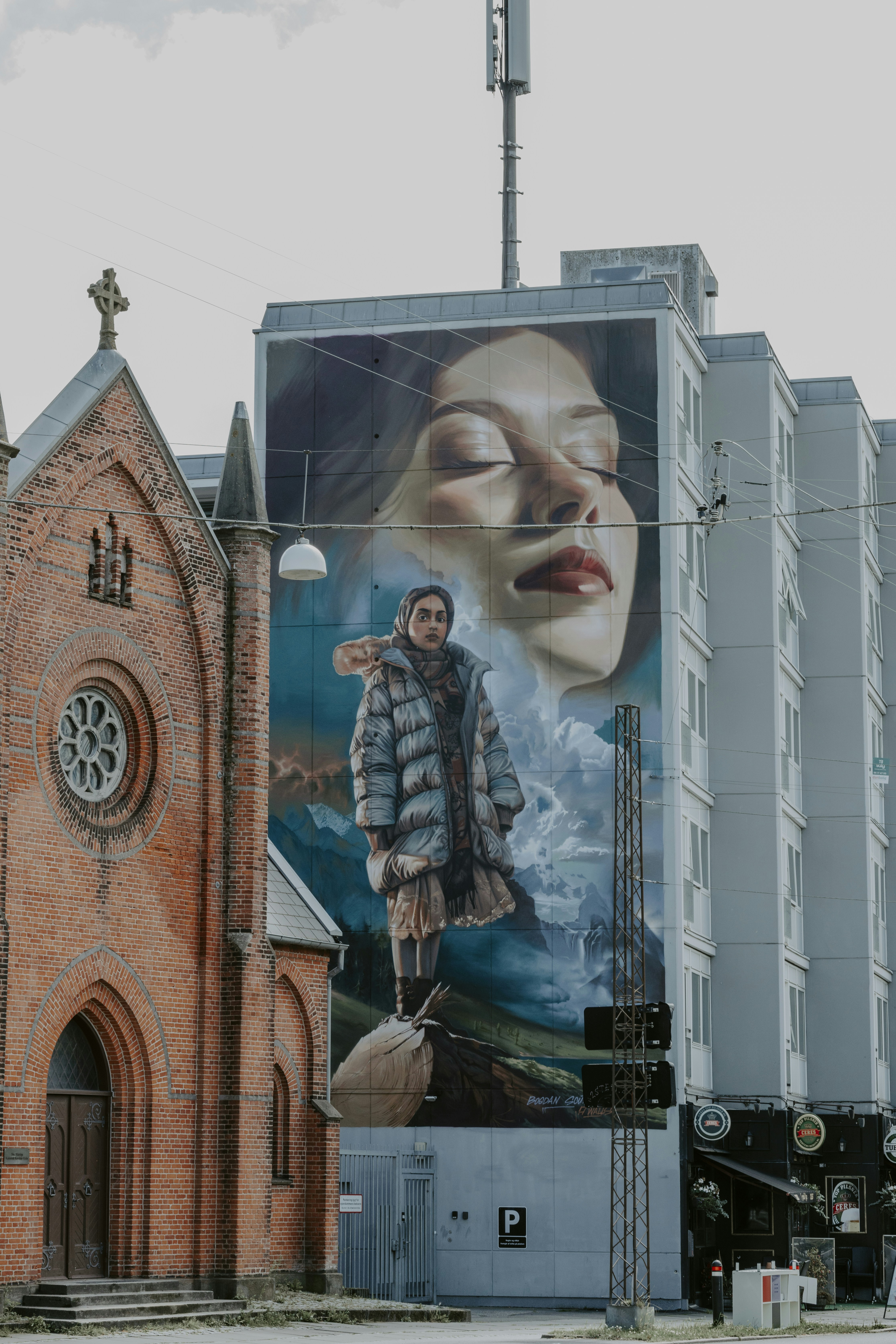 A large mural of a woman on the side of a building photo – Free Free ...