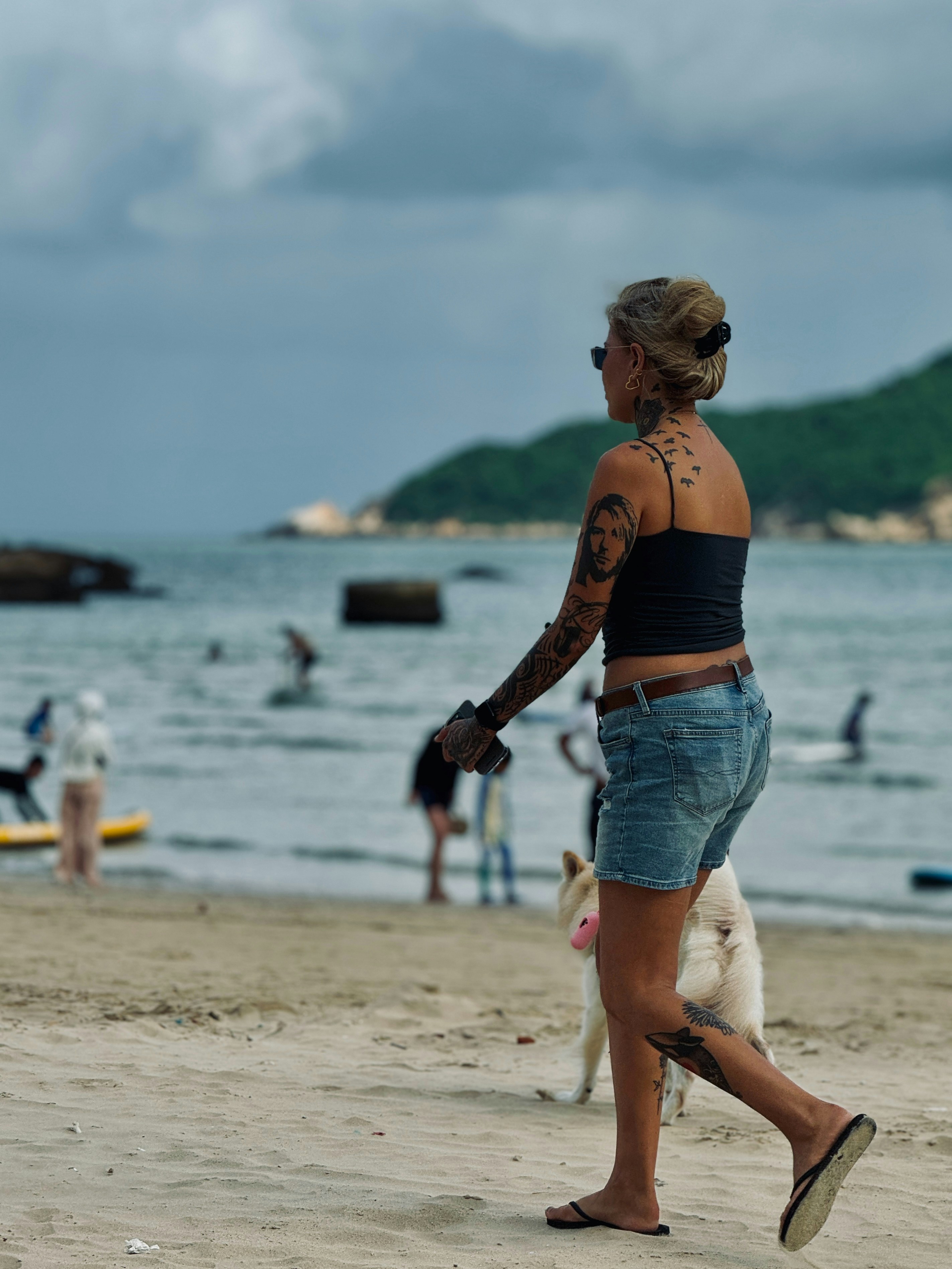On the Edge of the Sea: A Tattooed Figure in Denim Walks the Quiet Shore