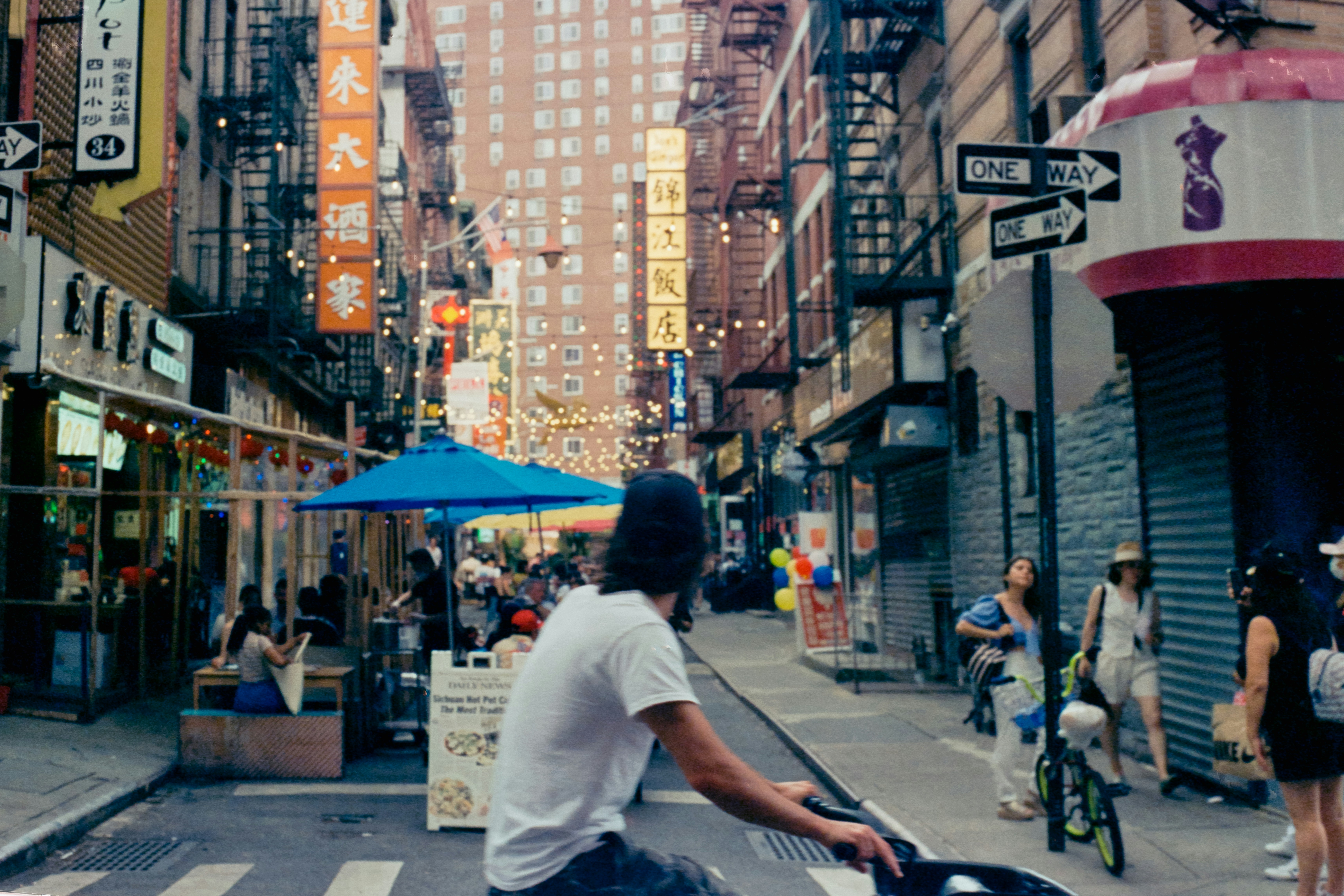 A man riding a scooter down a street next to tall buildings photo ...
