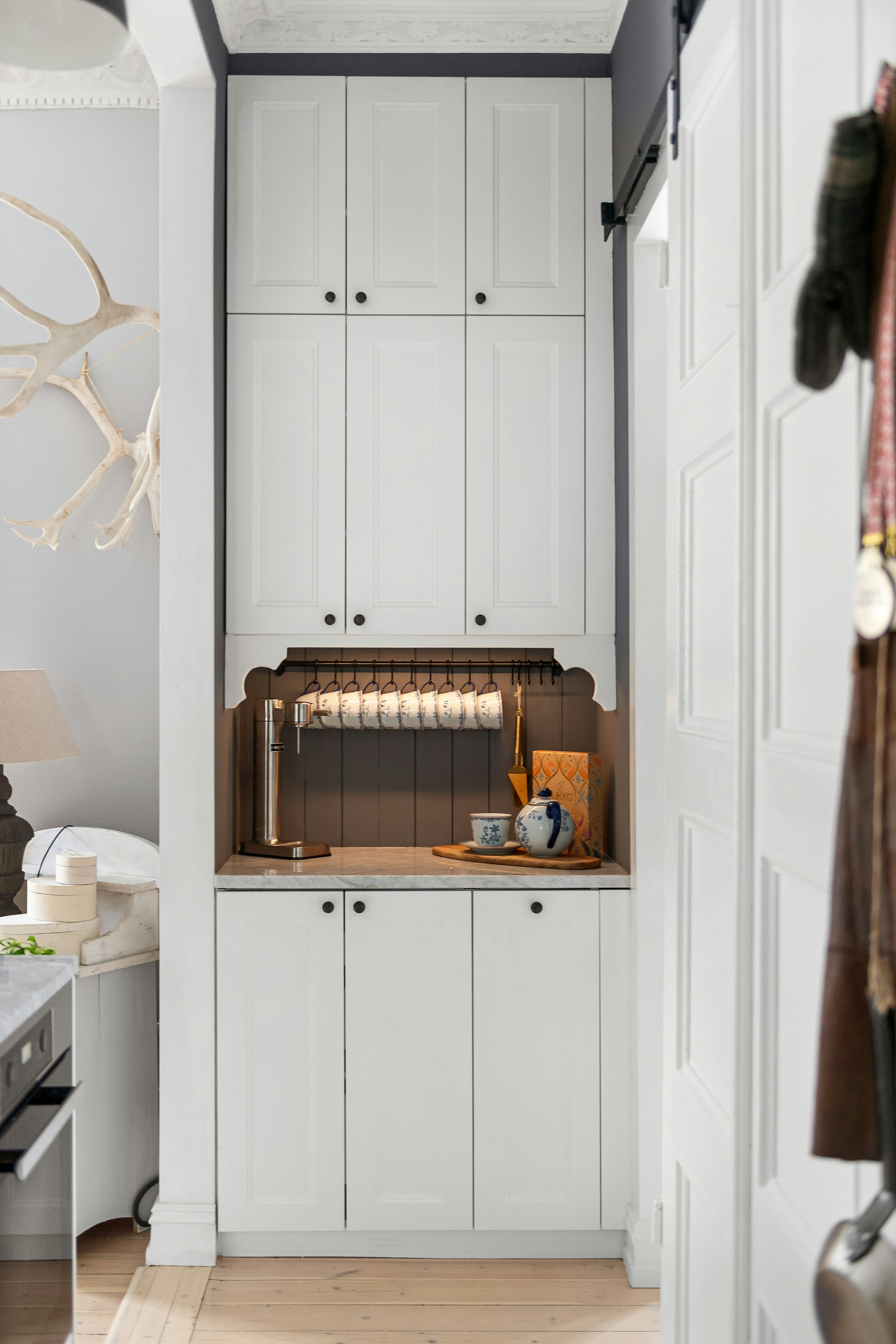 Built-in Nook: Quiet Kitchen Storage Rising with White Cabinetry