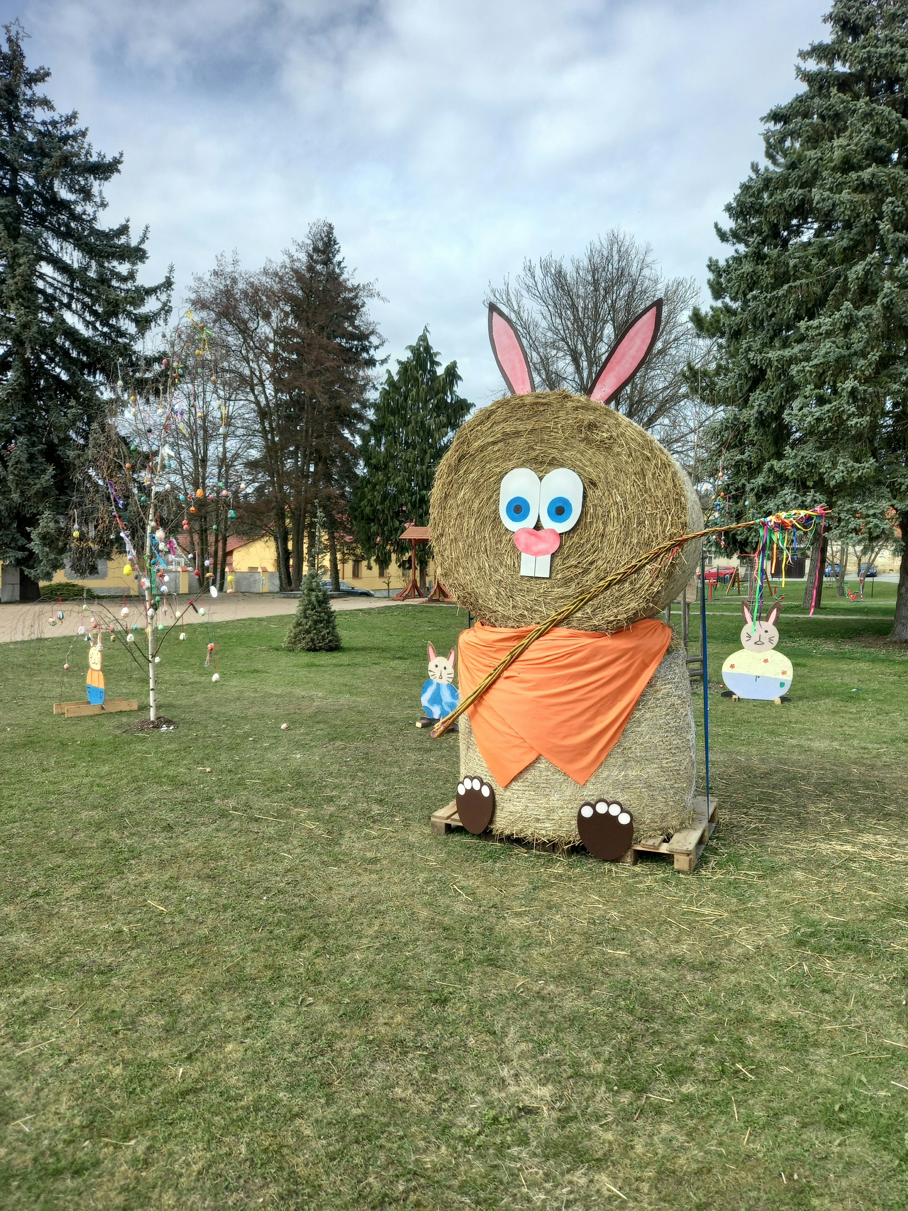 Bright-Eyed Hay Bale Bunny Guards a Spring Park