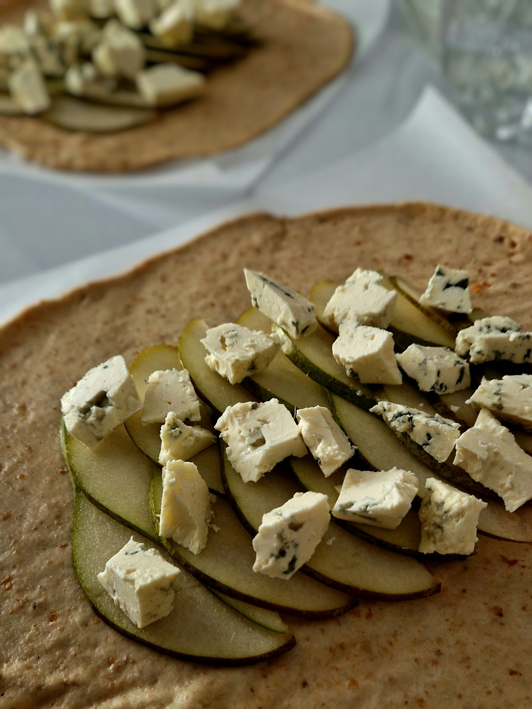 A table topped with a tortilla covered in cucumbers and cheese photo ...