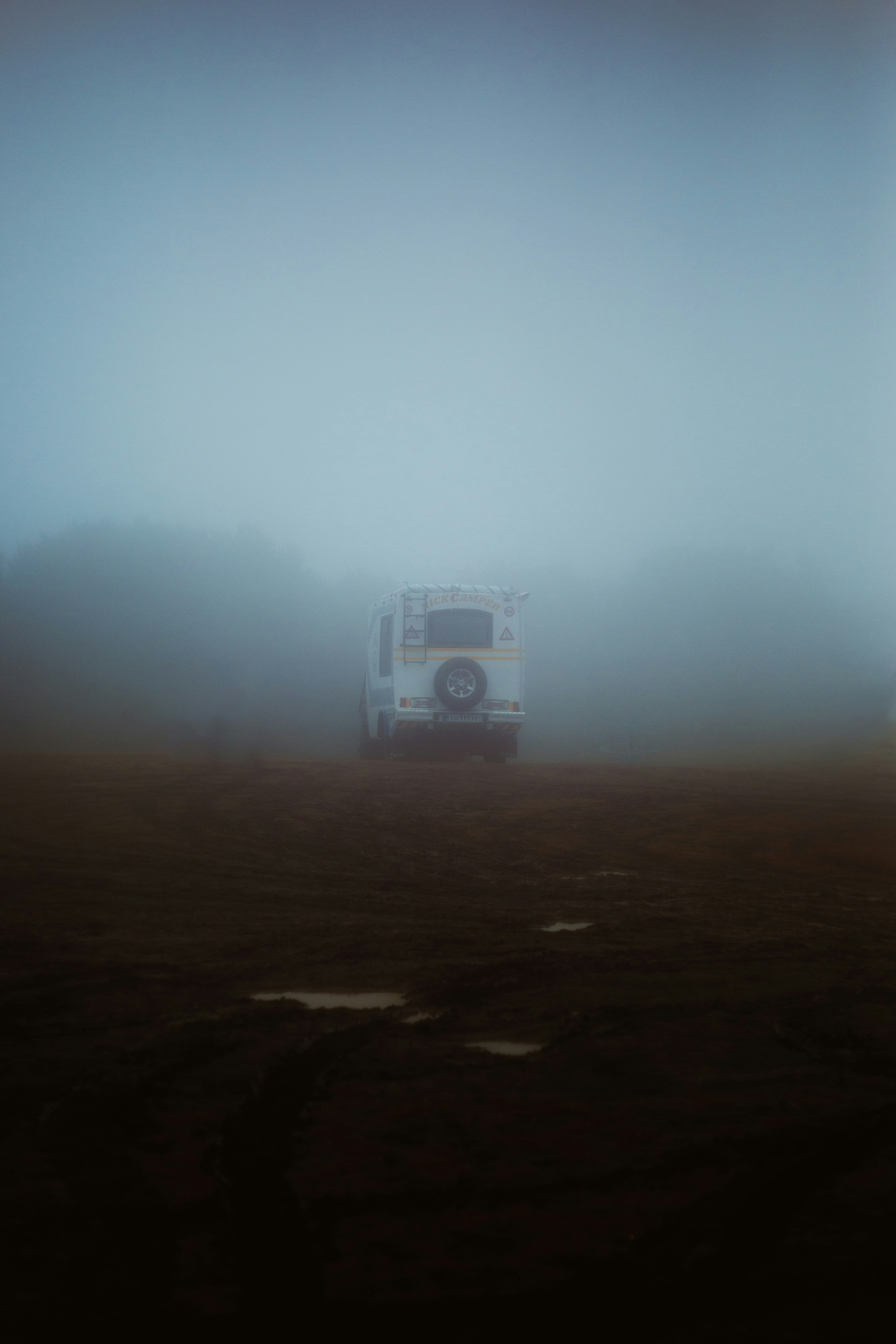 A truck driving through a foggy field