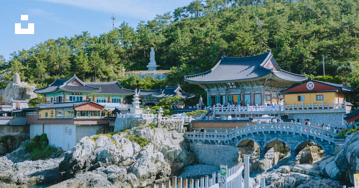 무성한 녹색 언덕 옆의 수역 위의 다리 사진 Unsplash의 무료 건물 이미지