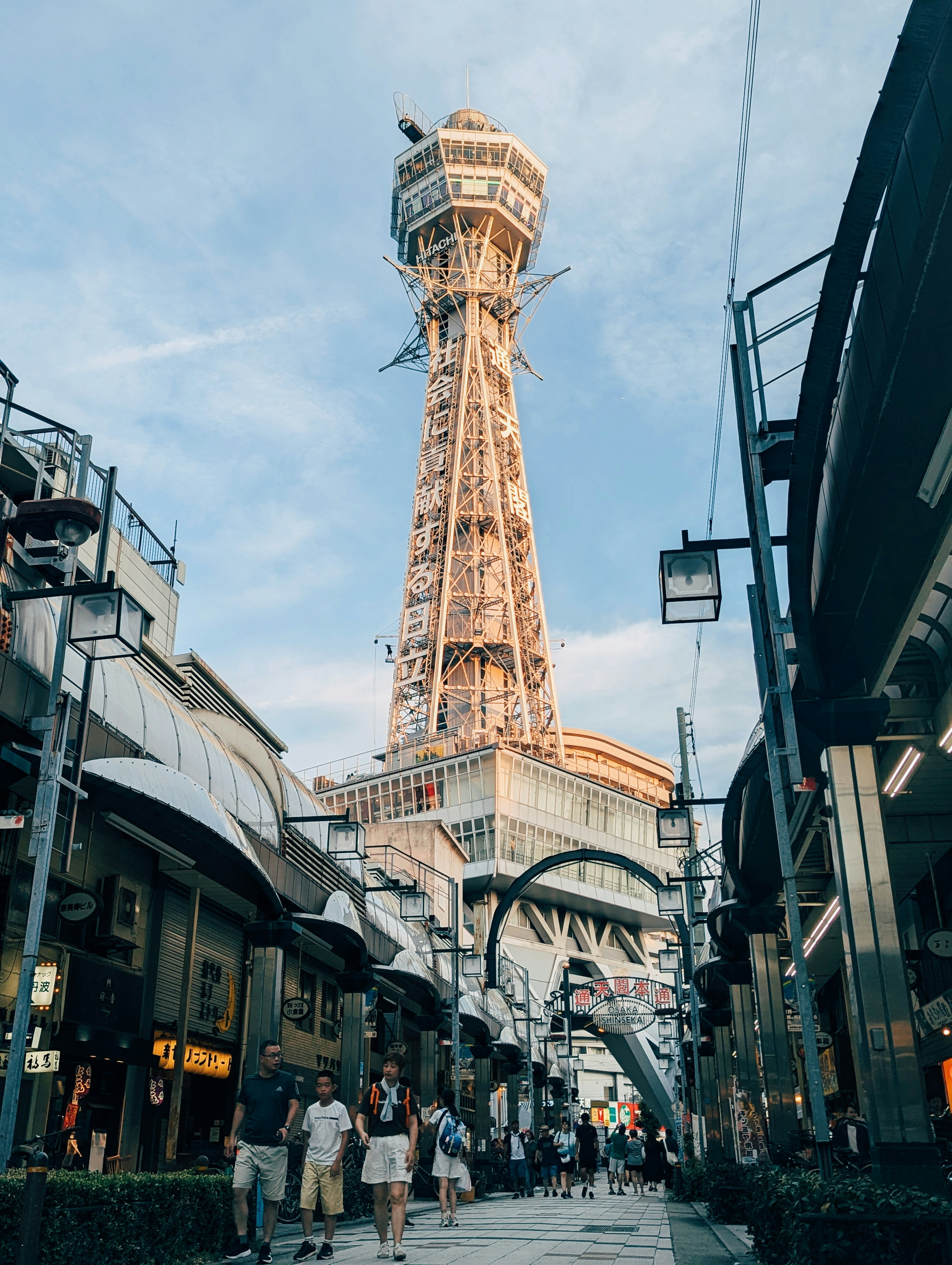 Lattice Tower Rising Over a Crowded Arcade